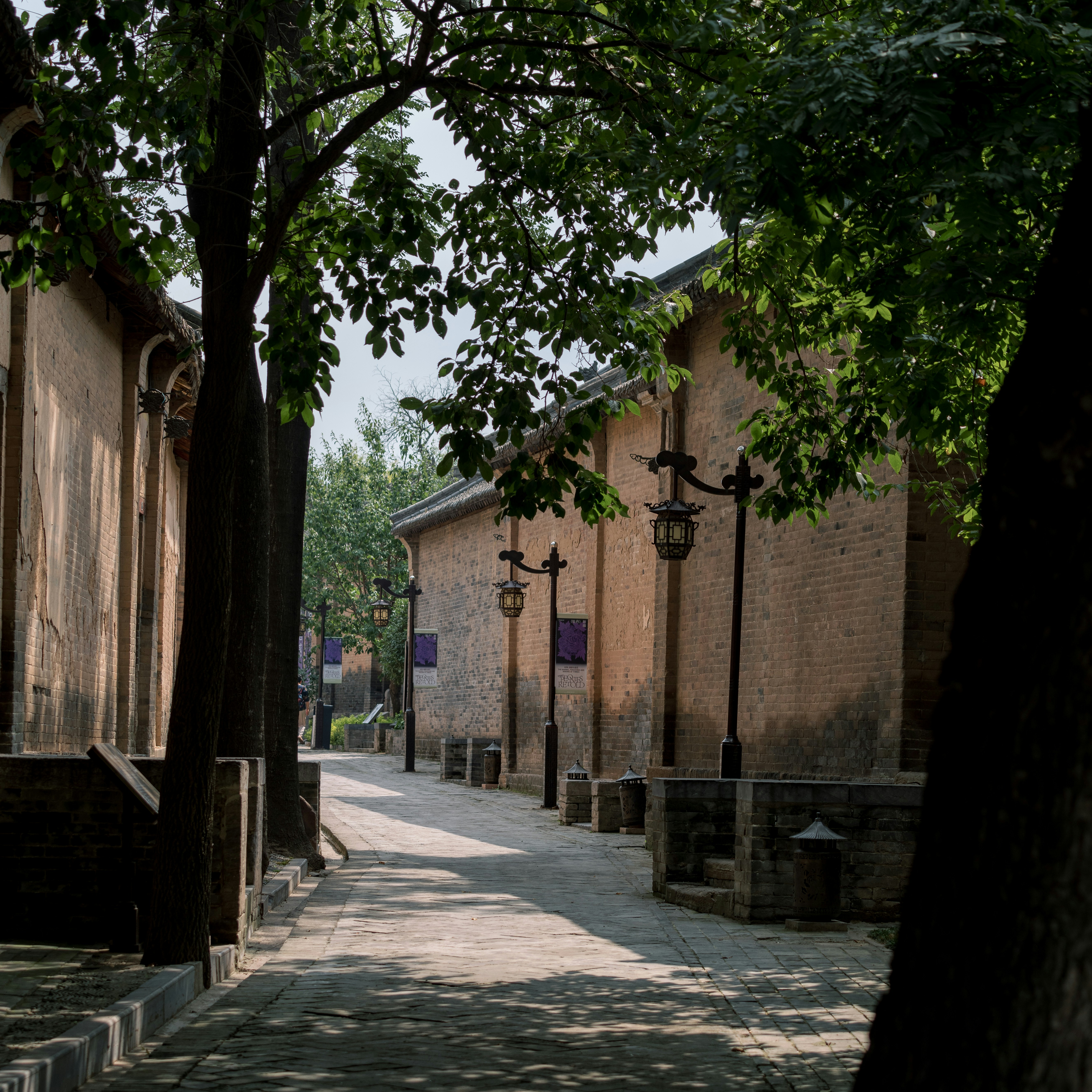 A shaded alleyway with brick buildings. photo – Free Building Image on ...