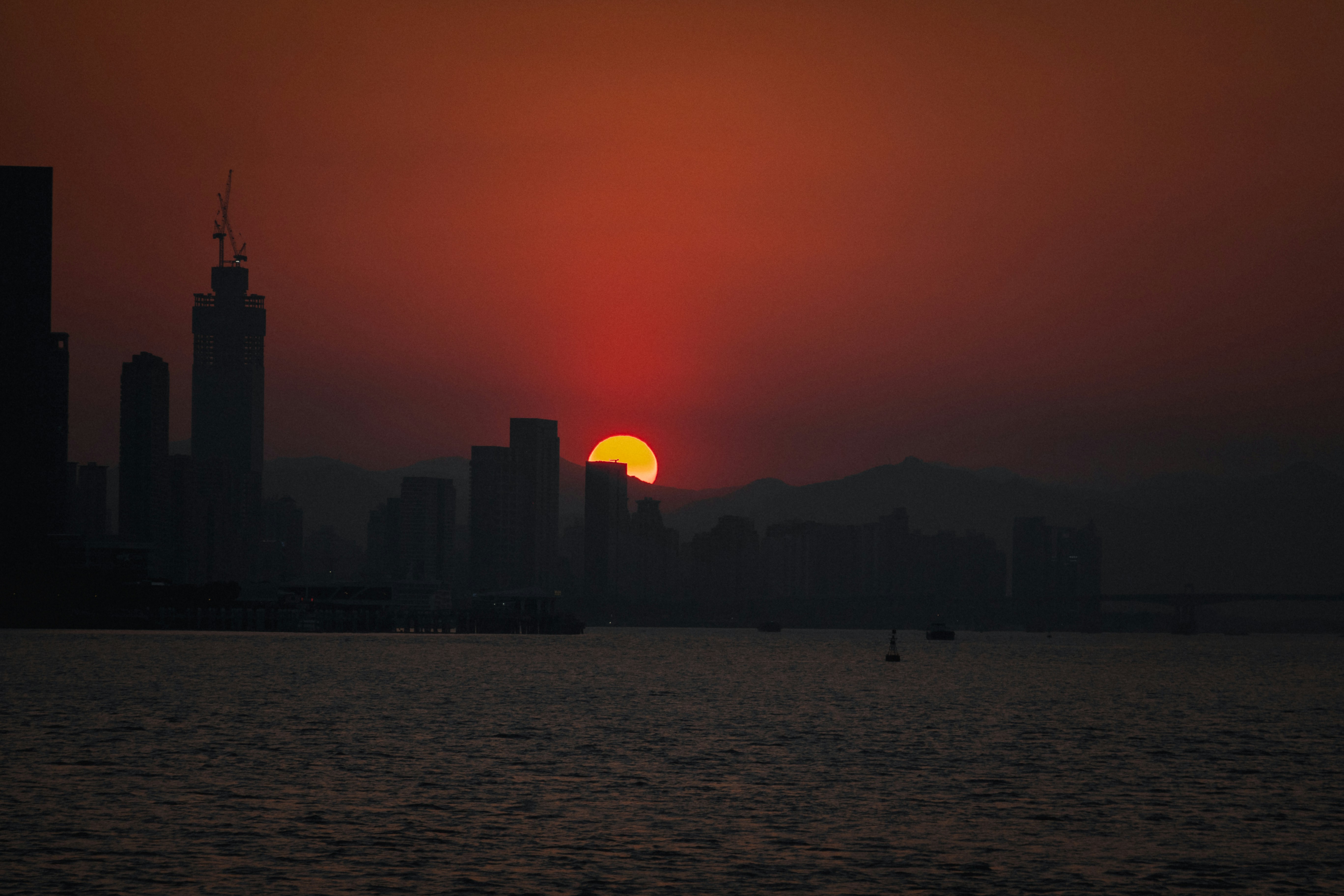 The sunset glows over the cityscape and water. photo – Free City Image ...