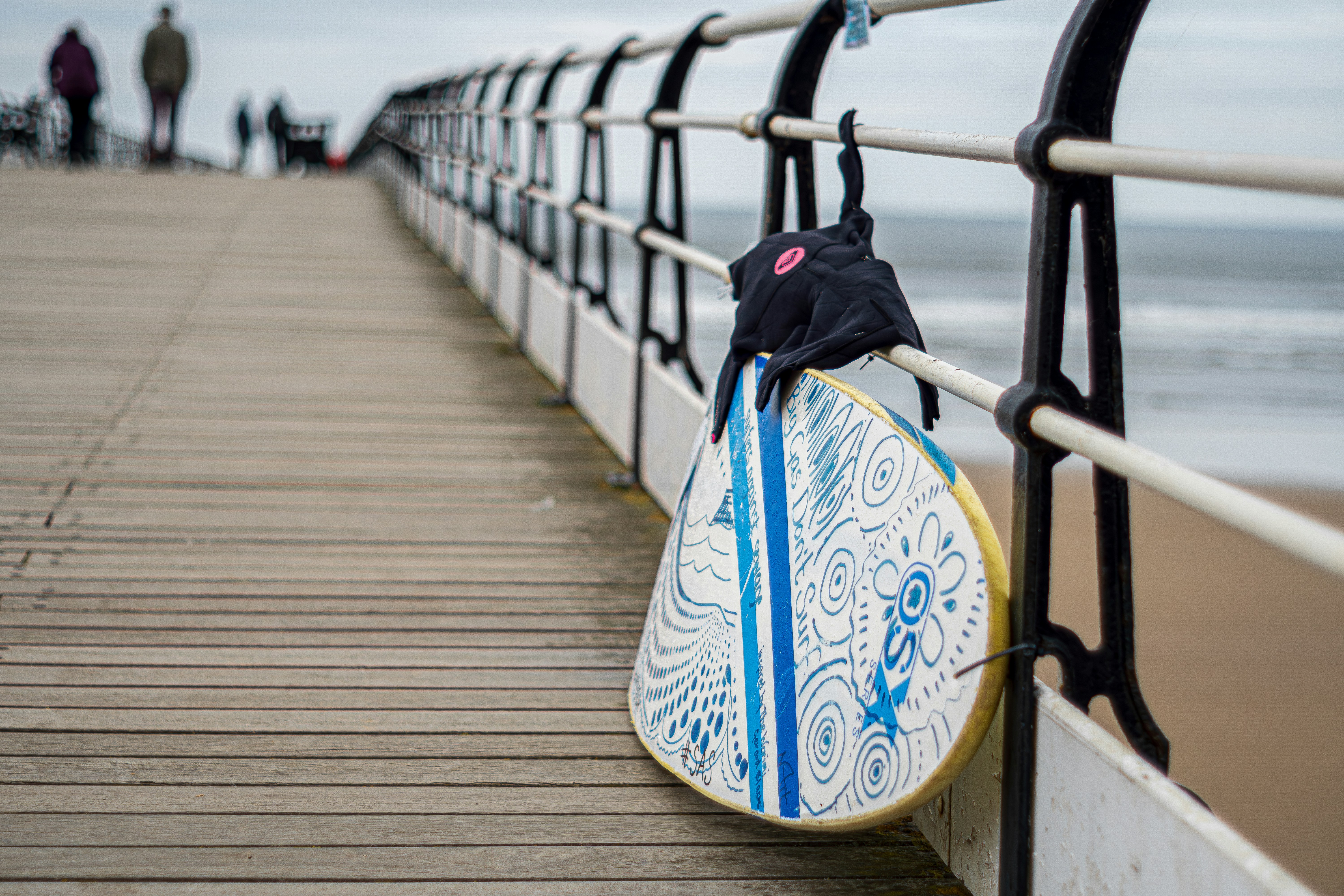 A surfboard and swimsuit hanging on a pier. photo – Free Sea Image on ...
