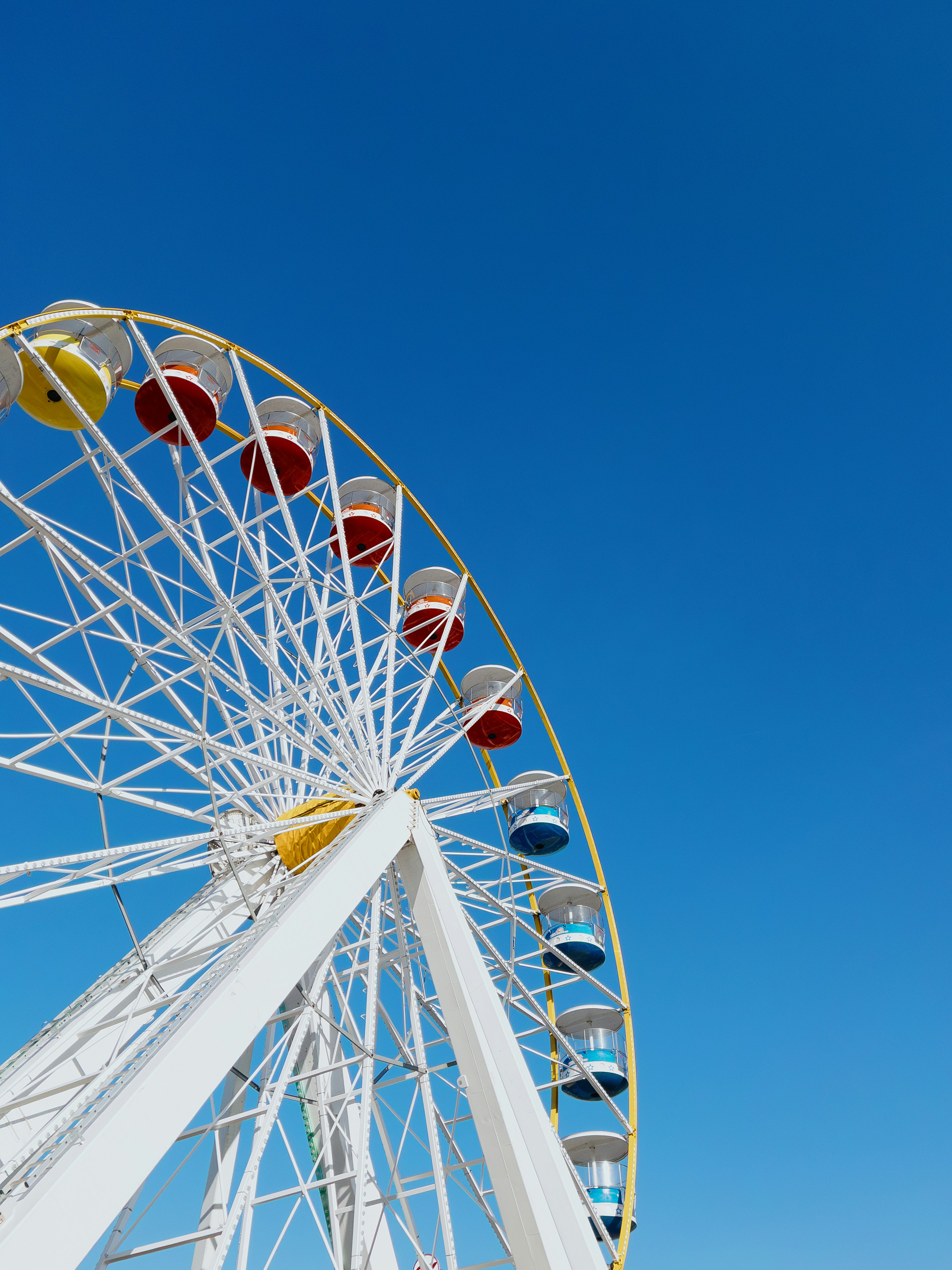 A ferris wheel stands against a bright blue sky. photo – Free Minimal ...