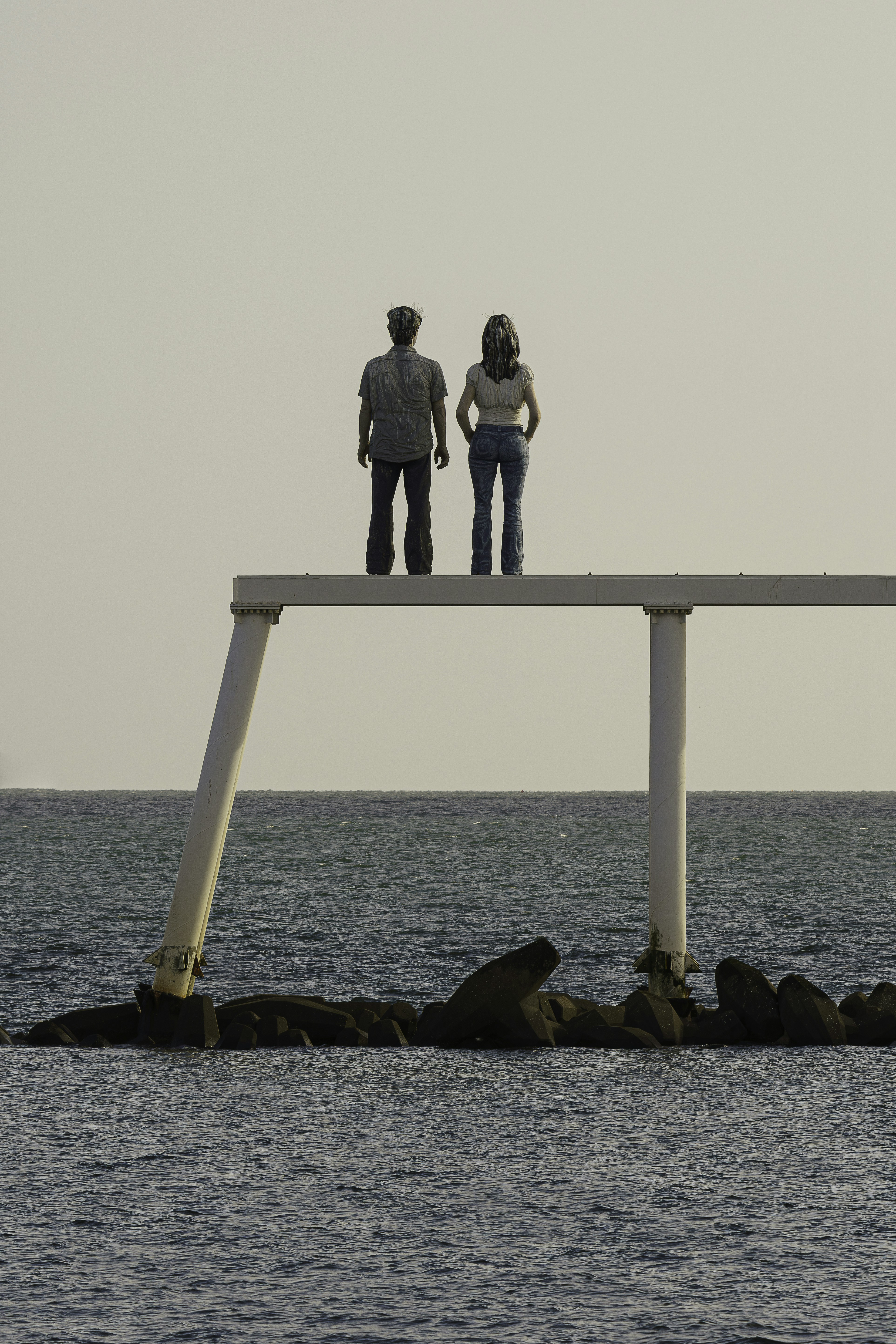 A couple stands overlooking the ocean. photo – Free Beach Image on Unsplash
