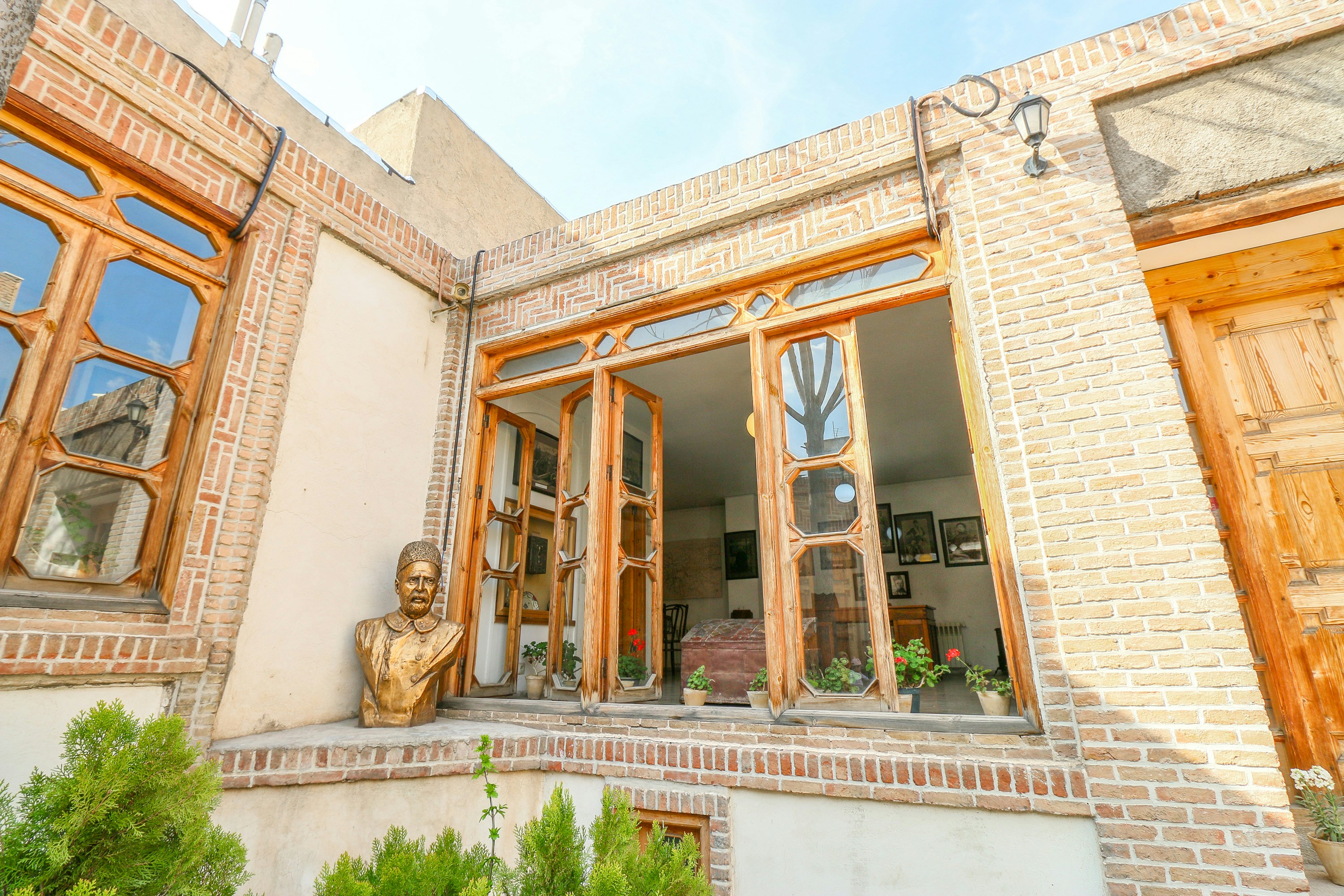 Sunlit Brick Courtyard Window with Sculptural Bust