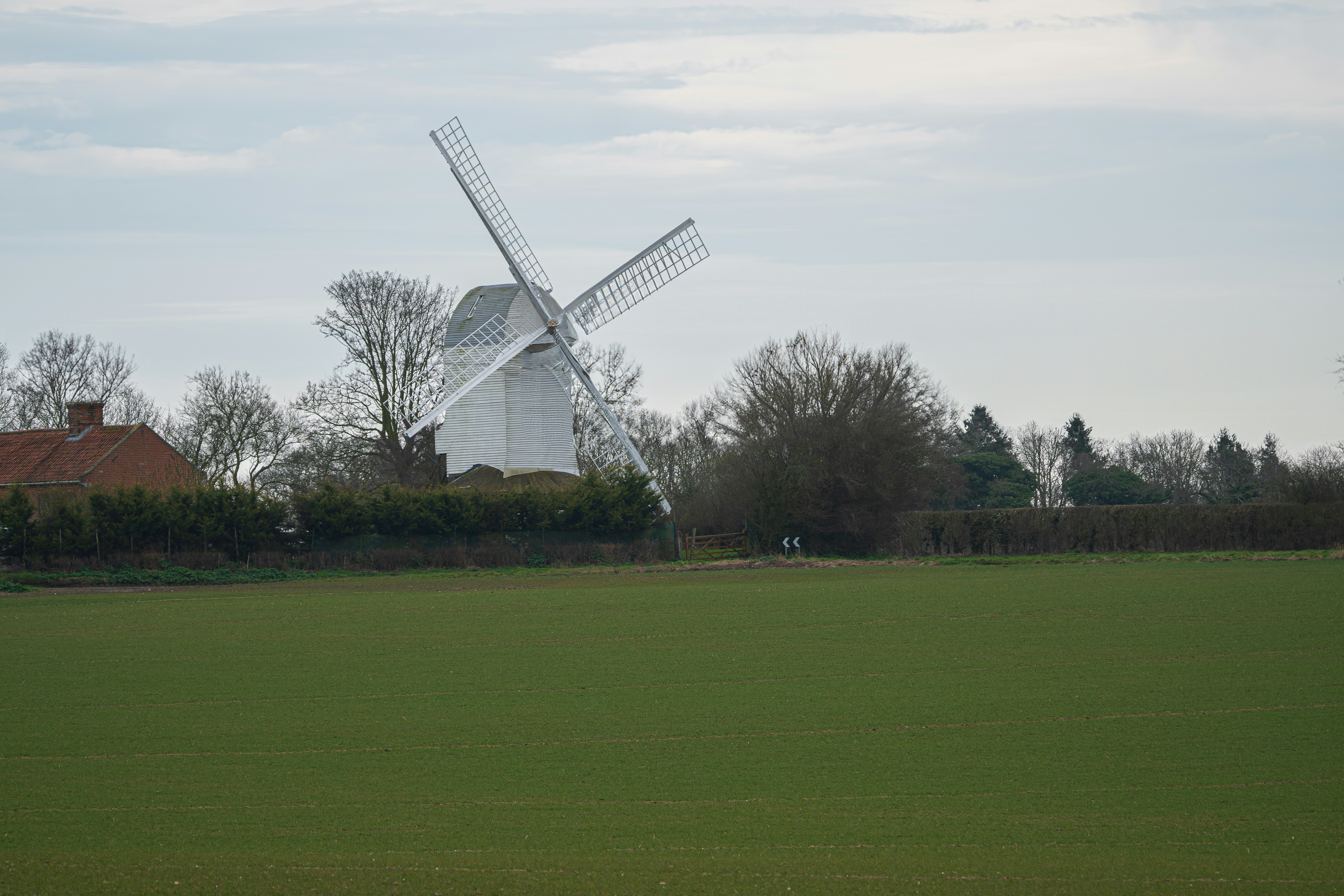 windmill in Norfolk, UK | A white windmill stands in a green field.