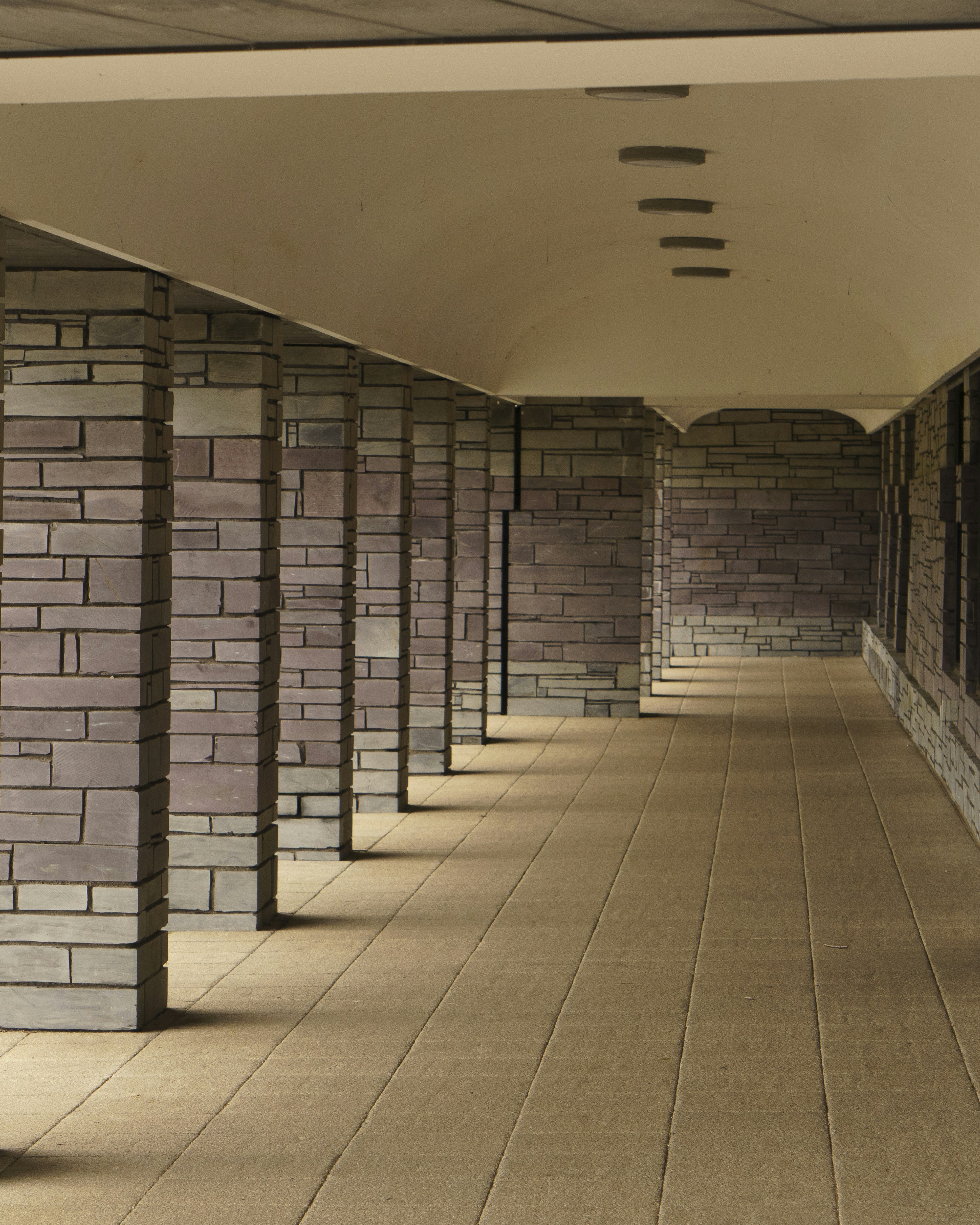 A corridor with stone pillars and a textured floor. photo – Free ...