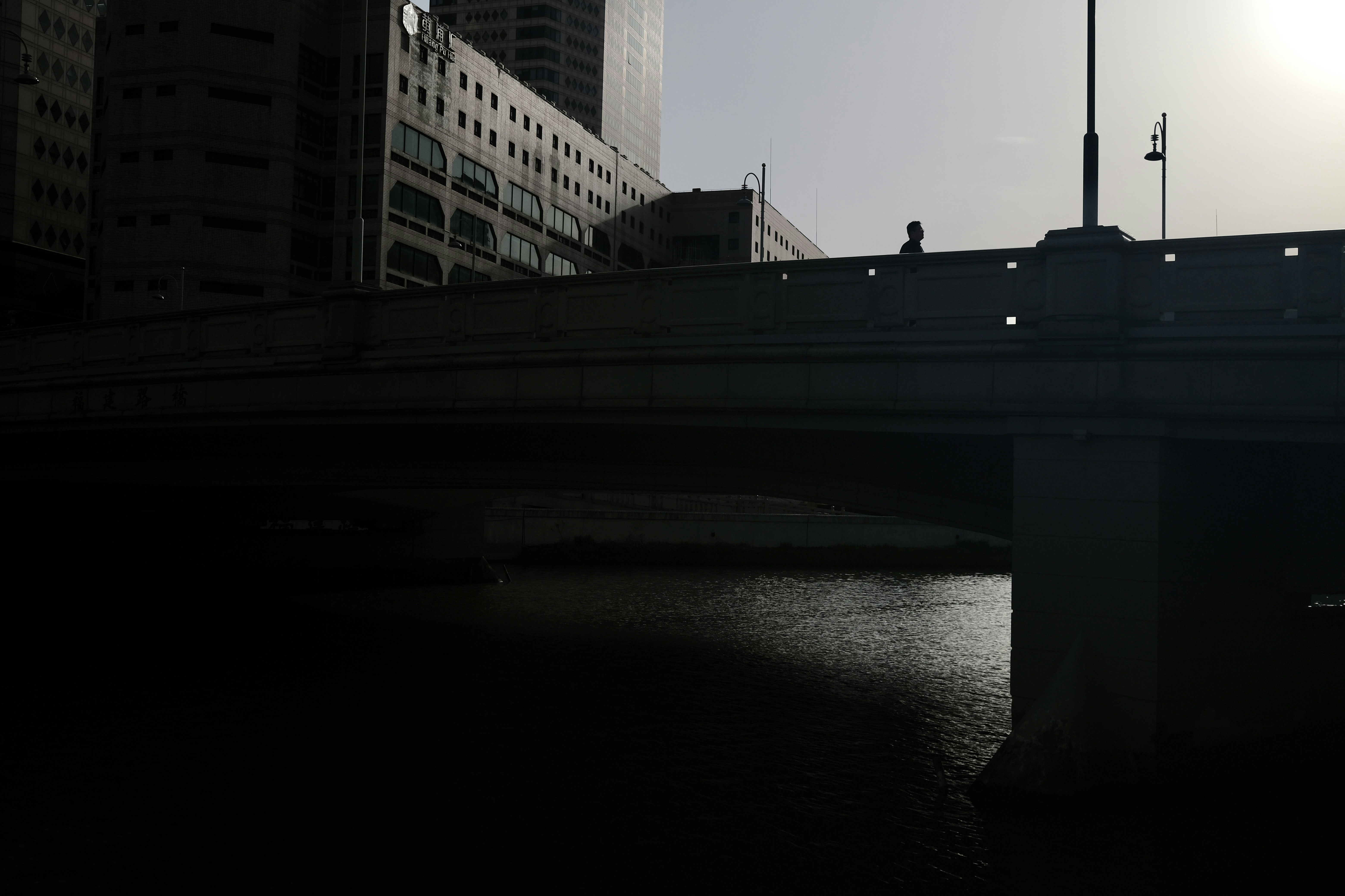 Neon Shadows Over the River: A Night Bridge Silhouette