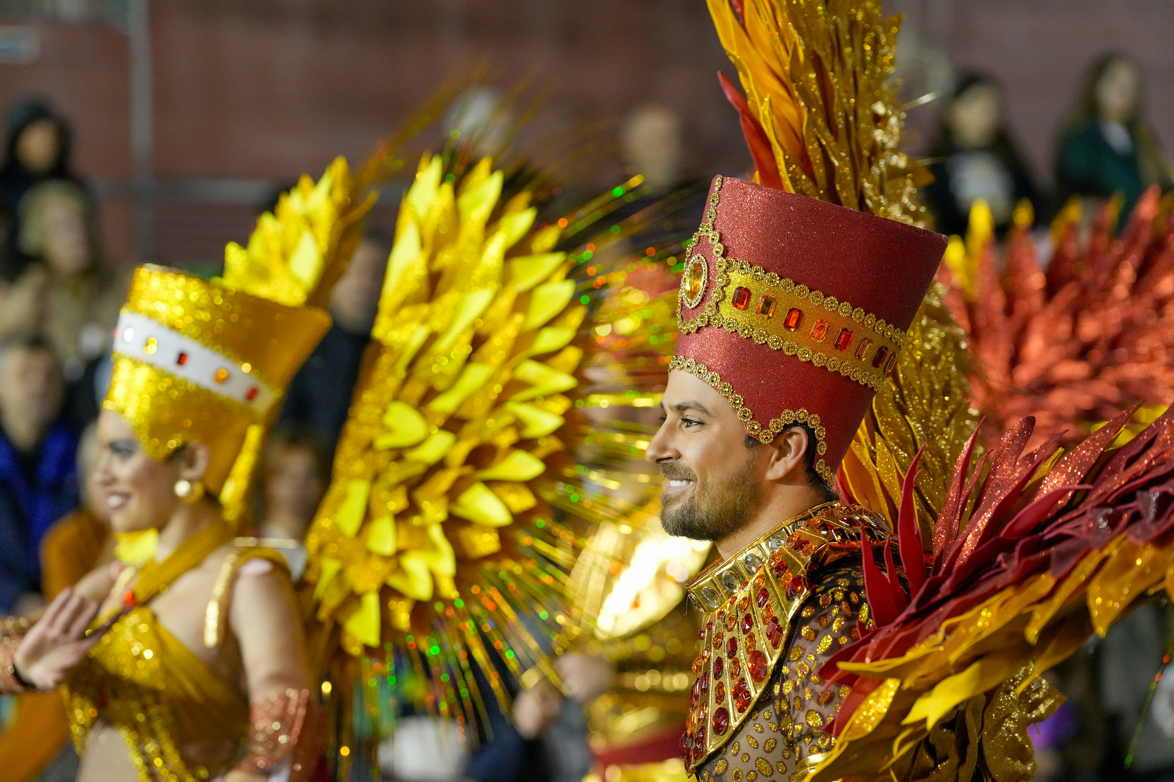 People in elaborate costumes are enjoying a parade.