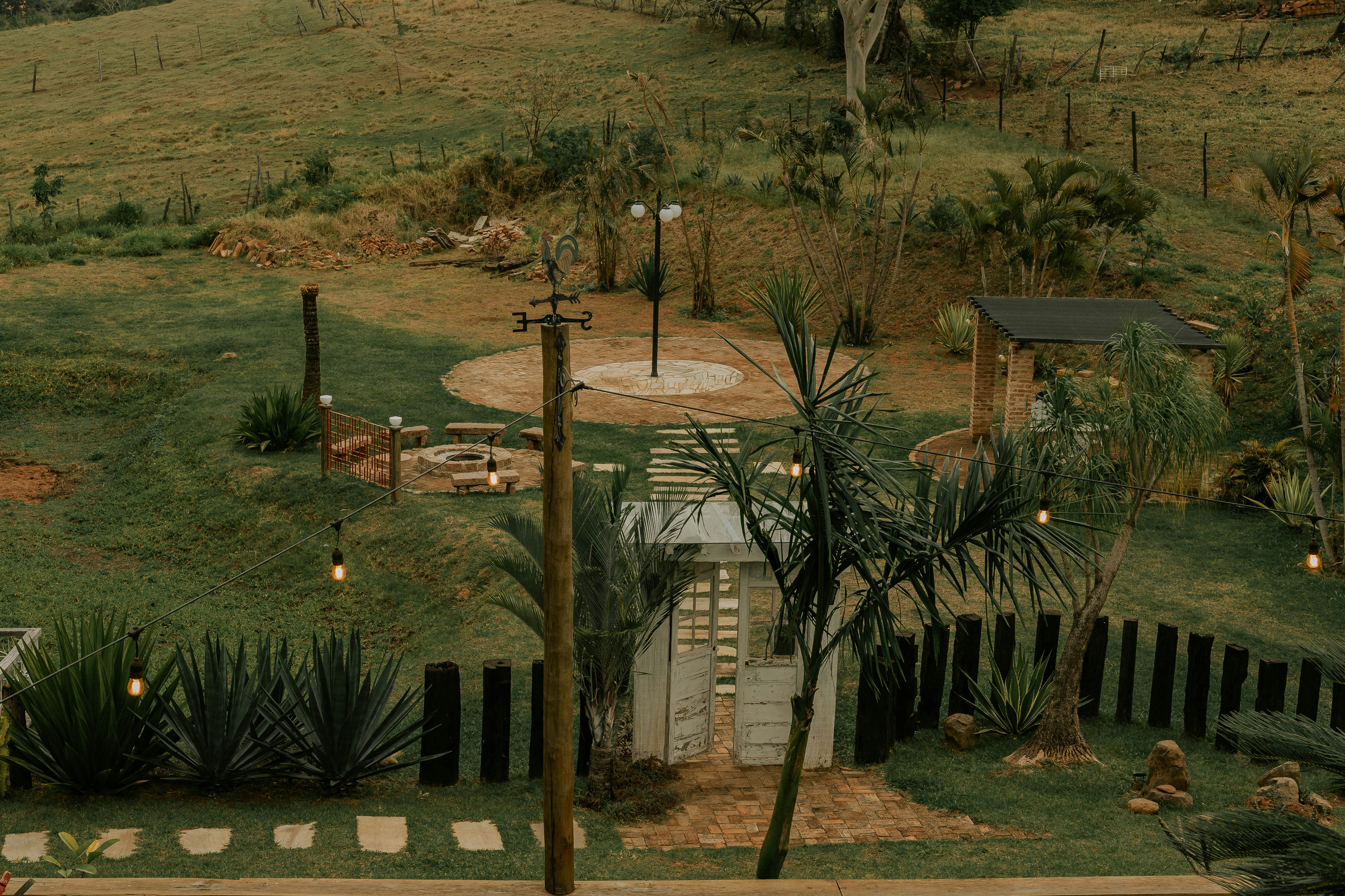 Lush garden with stone pathway, tall trees, and ambient lighting enhancing a tranquil scene.