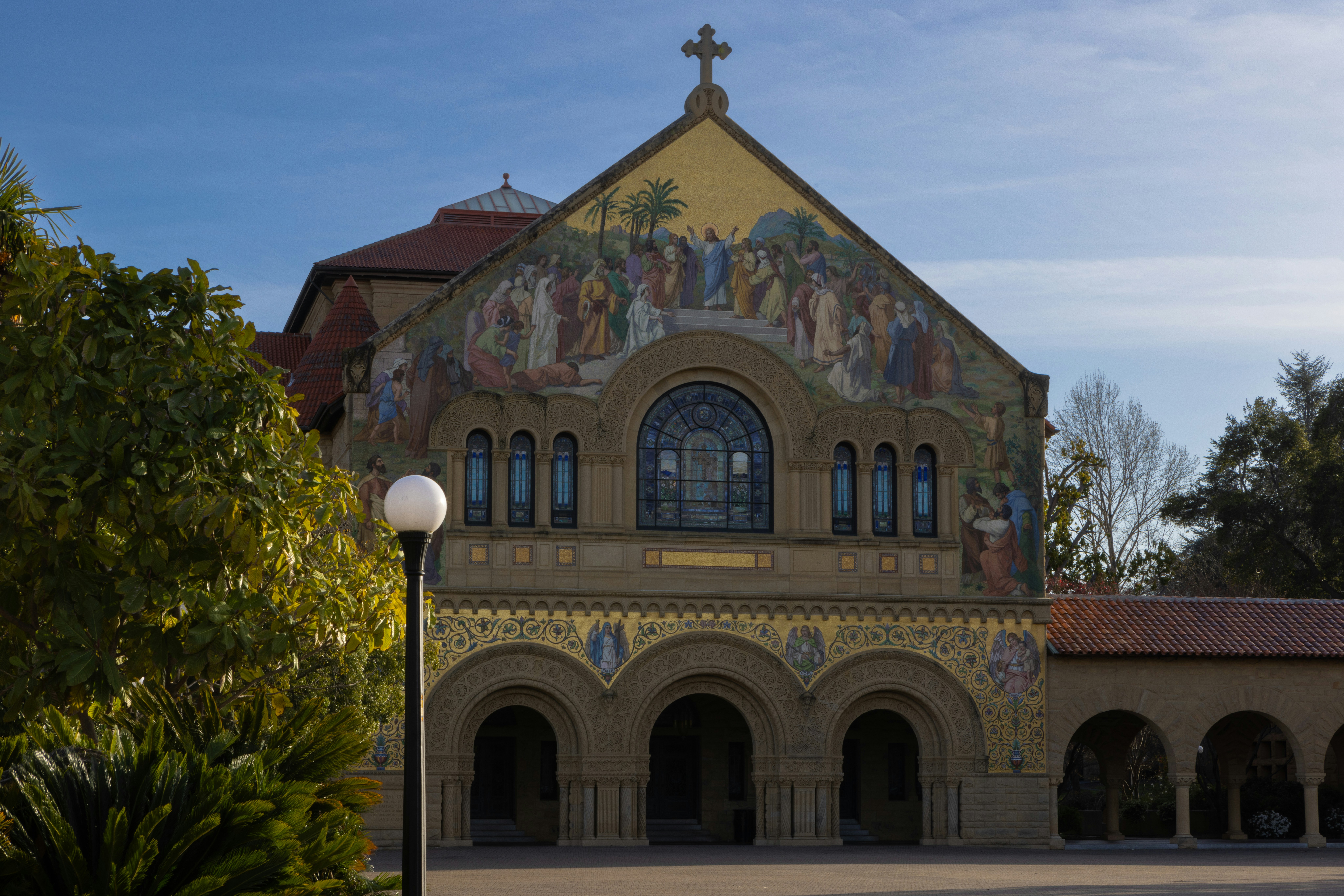 Historic building facade featuring intricate mosaics and arches under a clear sky.
