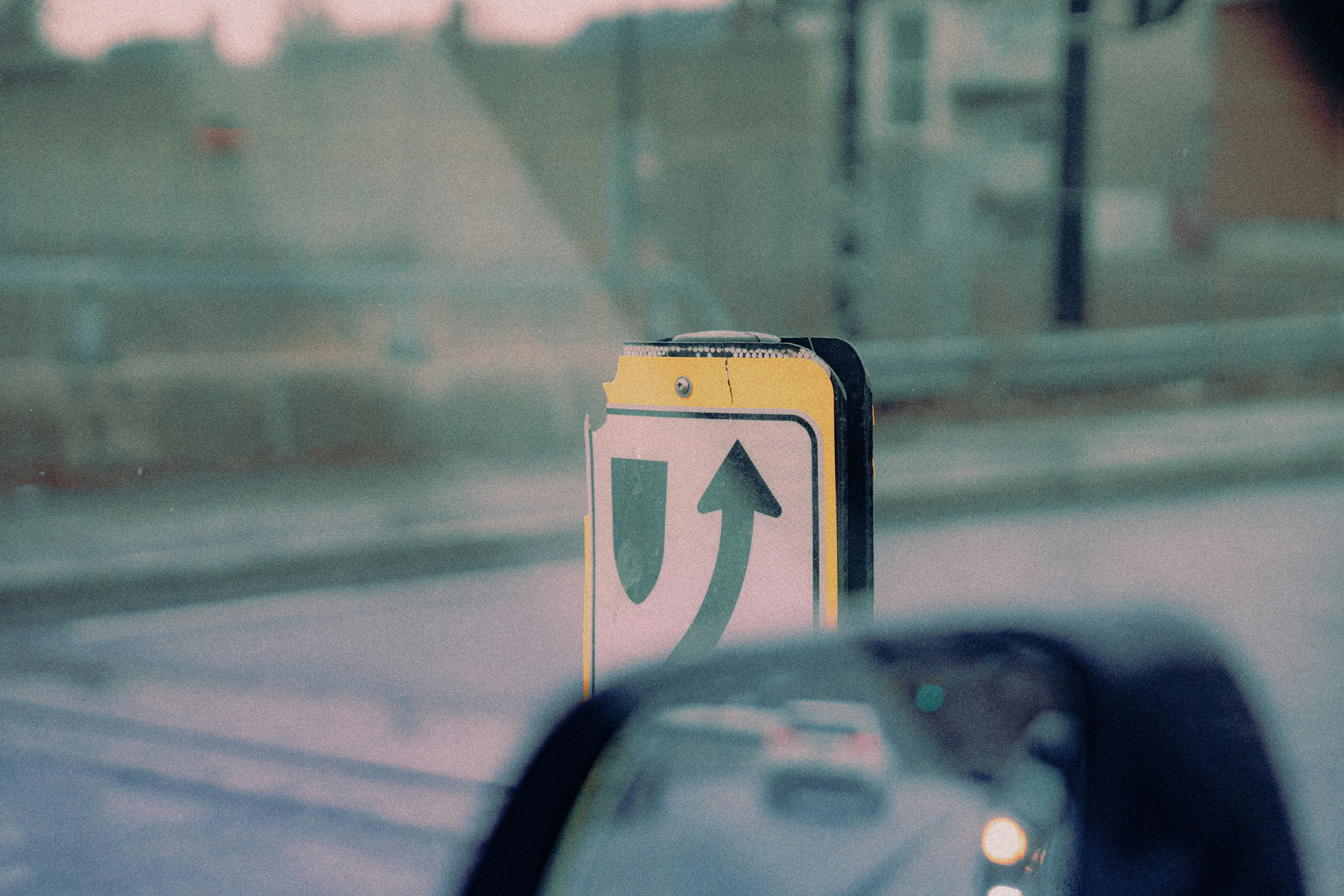 Turn Ahead: A Weathered U-Turn Sign Framed by a Car Window