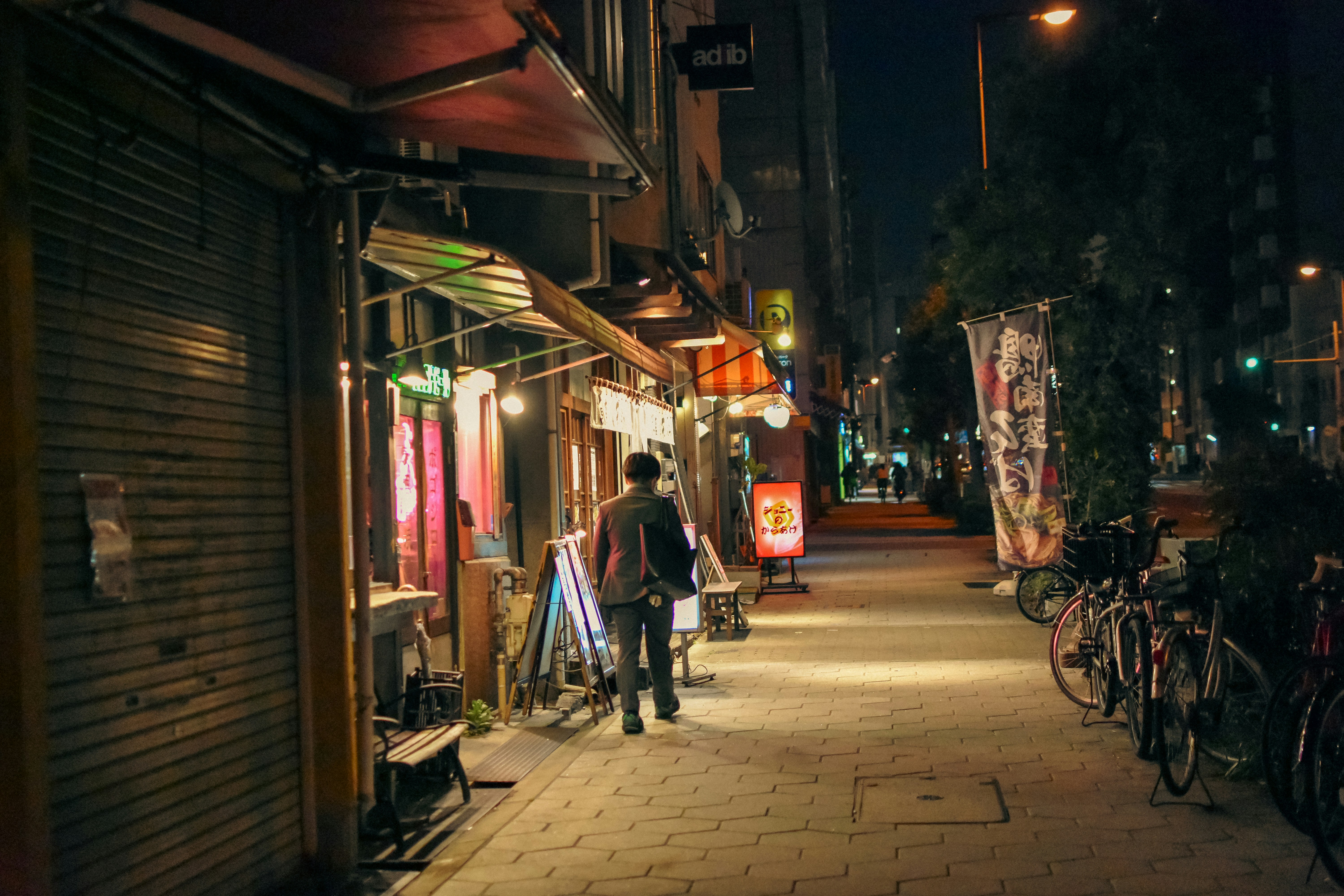 Two people stroll down a dimly lit city street. photo – Free City Image ...
