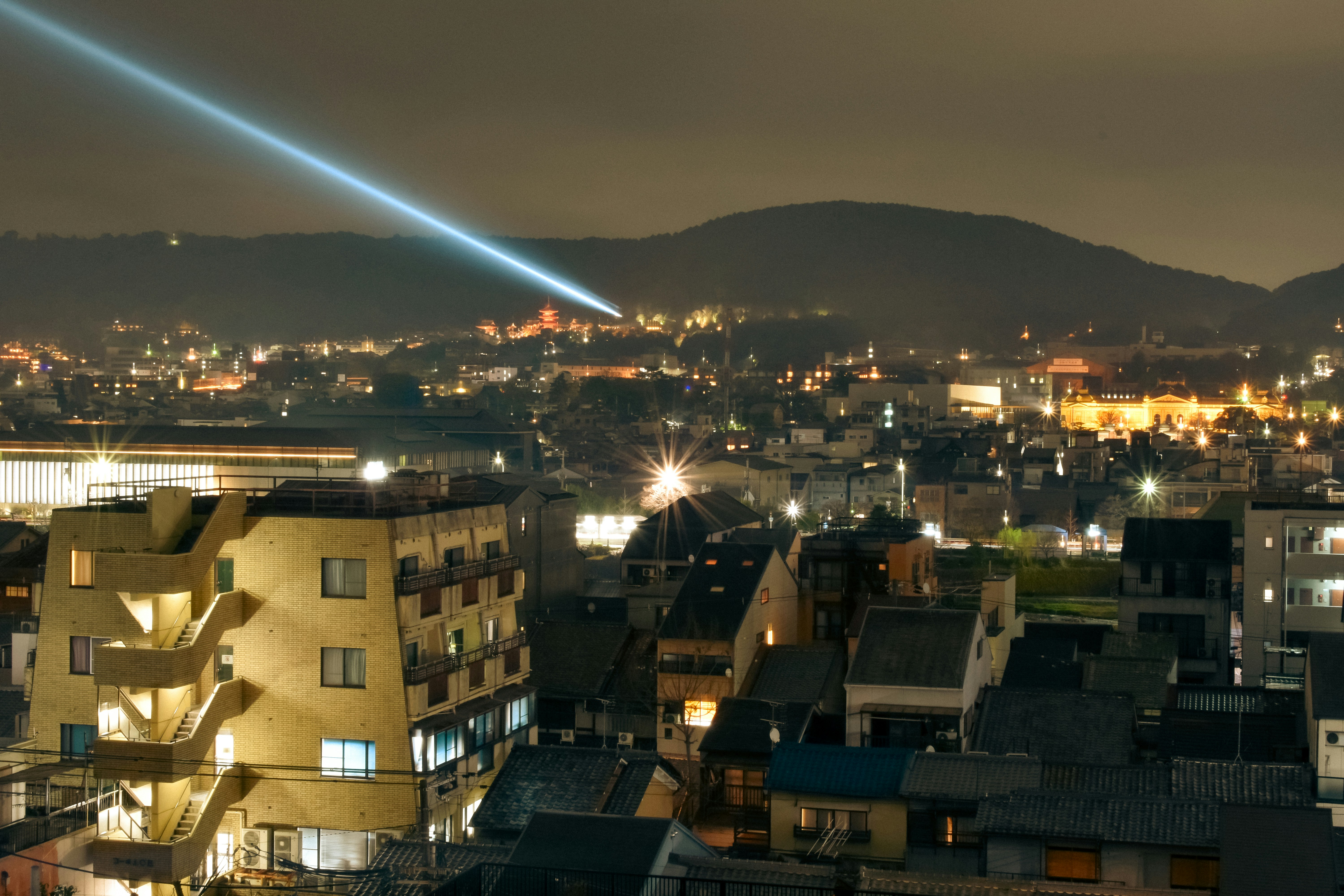 Blue Arc Over the Night Skyline: A City Illuminated by a Single Laser Beam
