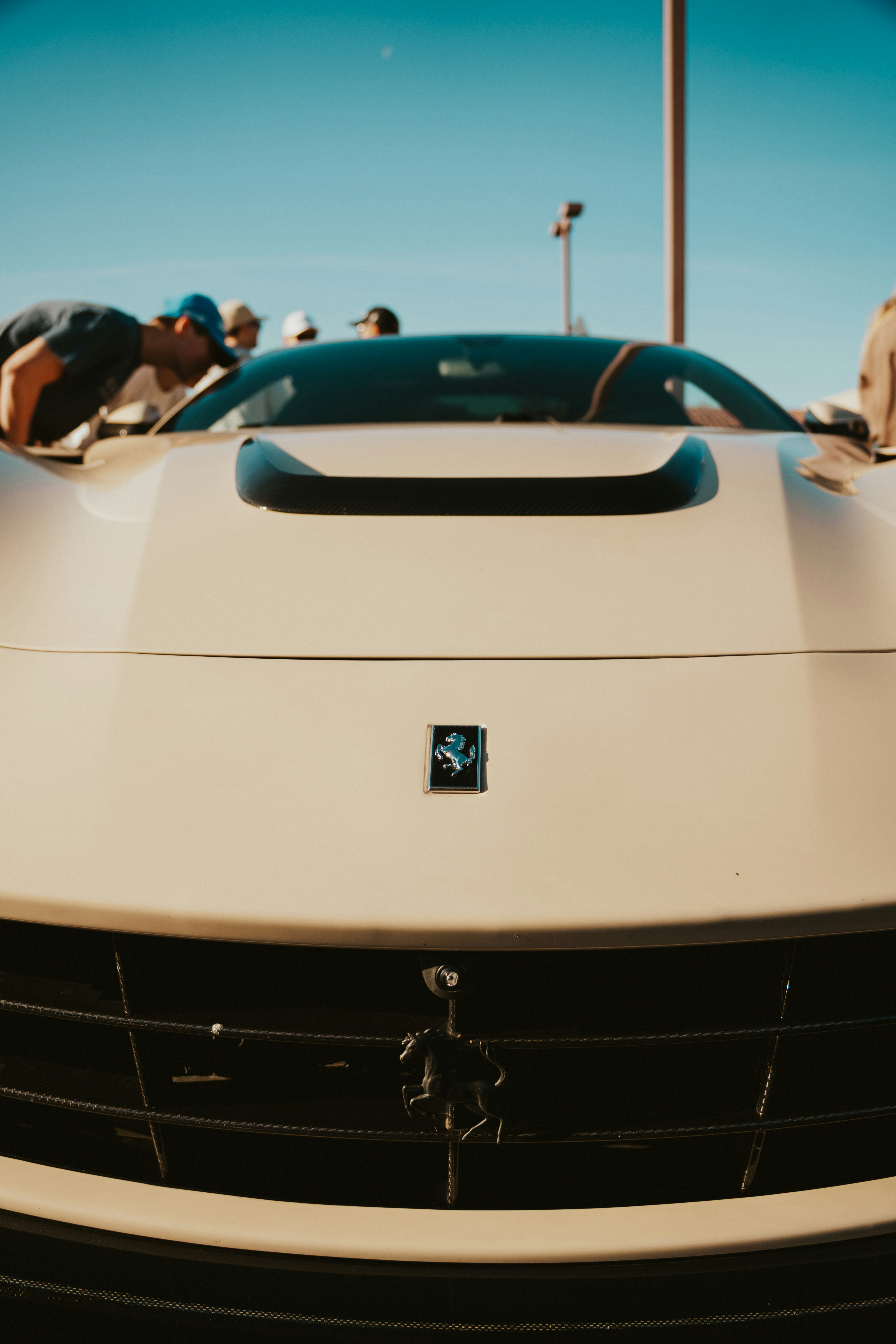 People admire a shiny white ferrari