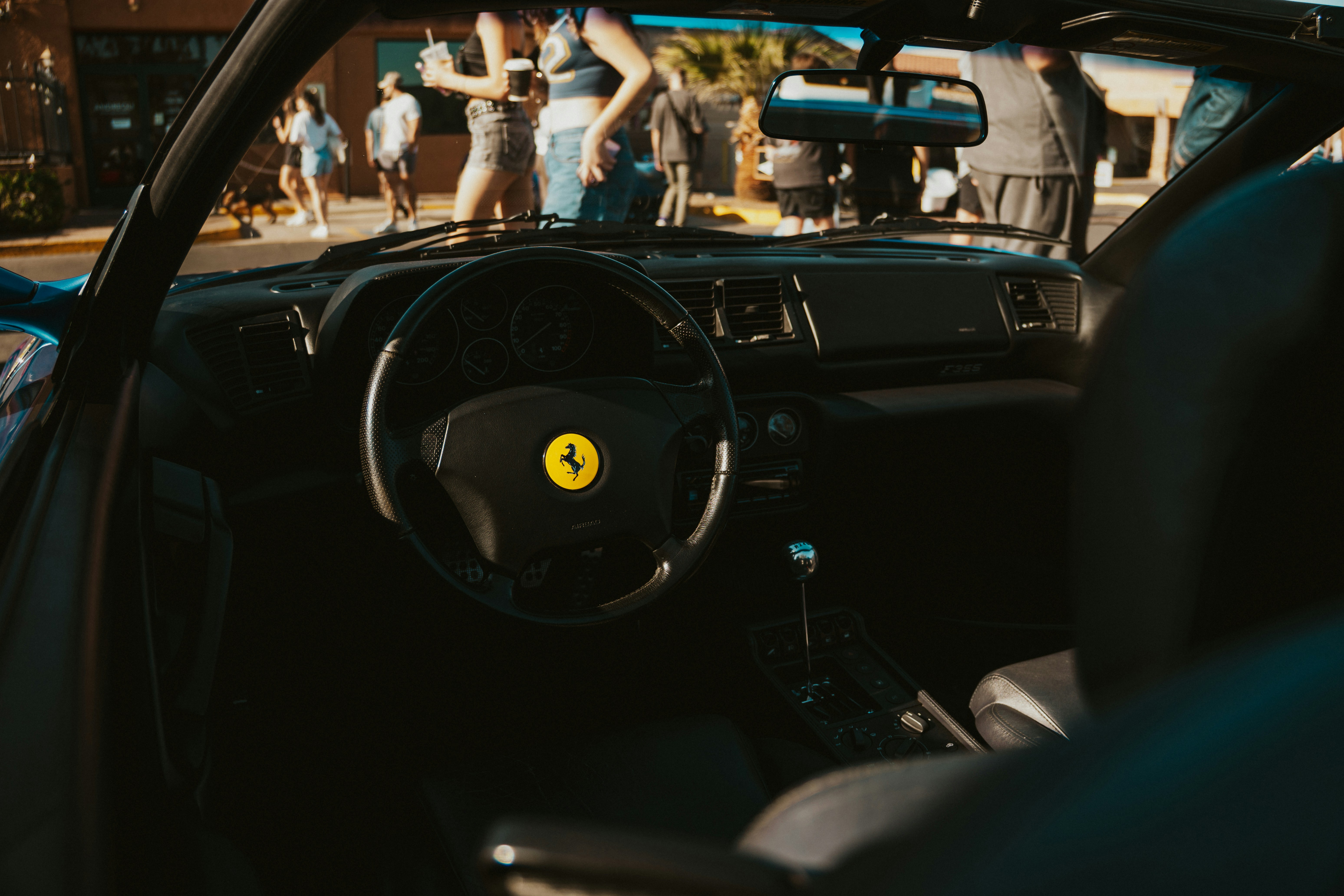 Ferrari Cockpit: Dark Heart Framed by a Sunlit Crowd