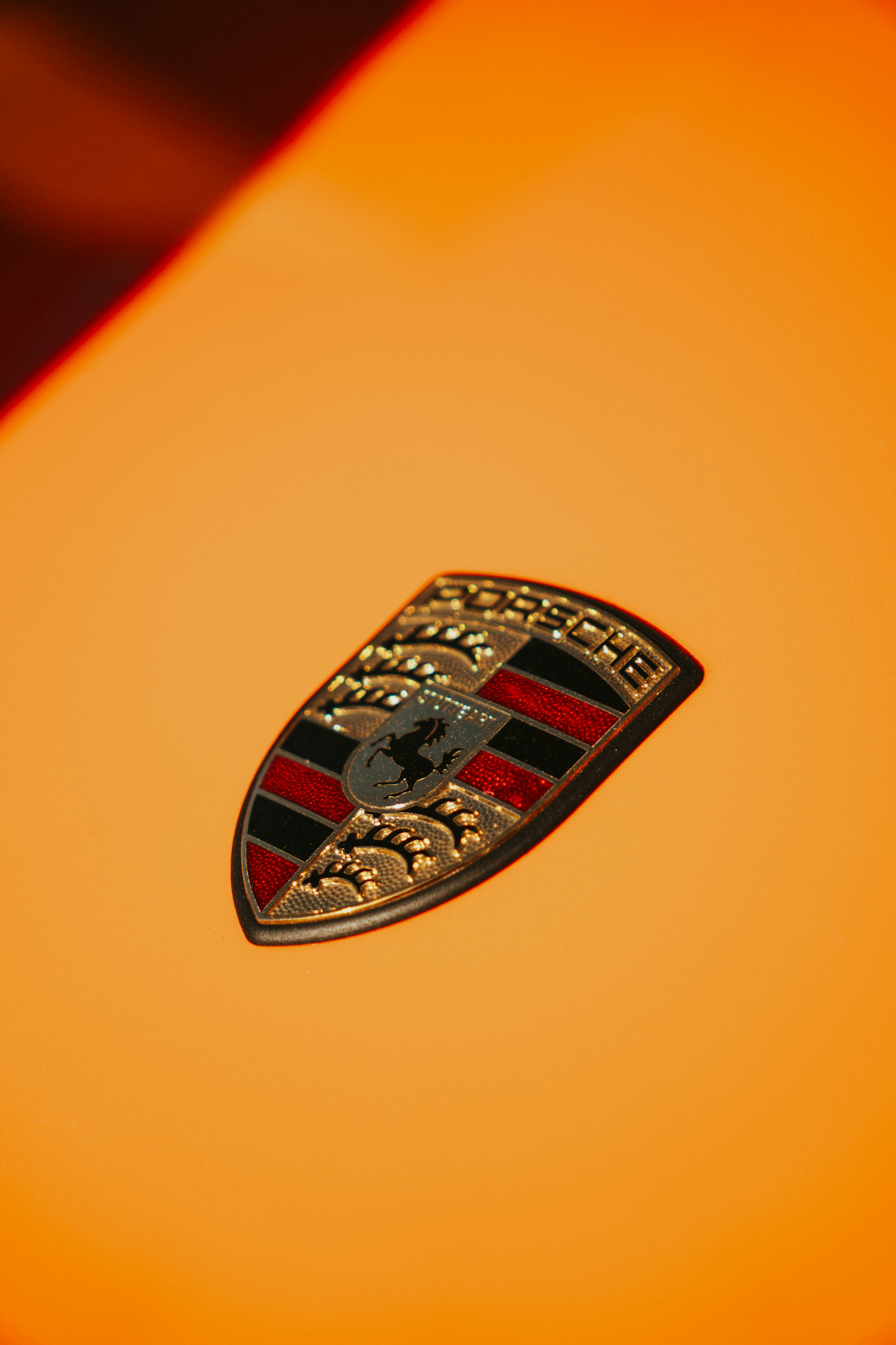 Porsche Crest on a Sunlit Orange Field