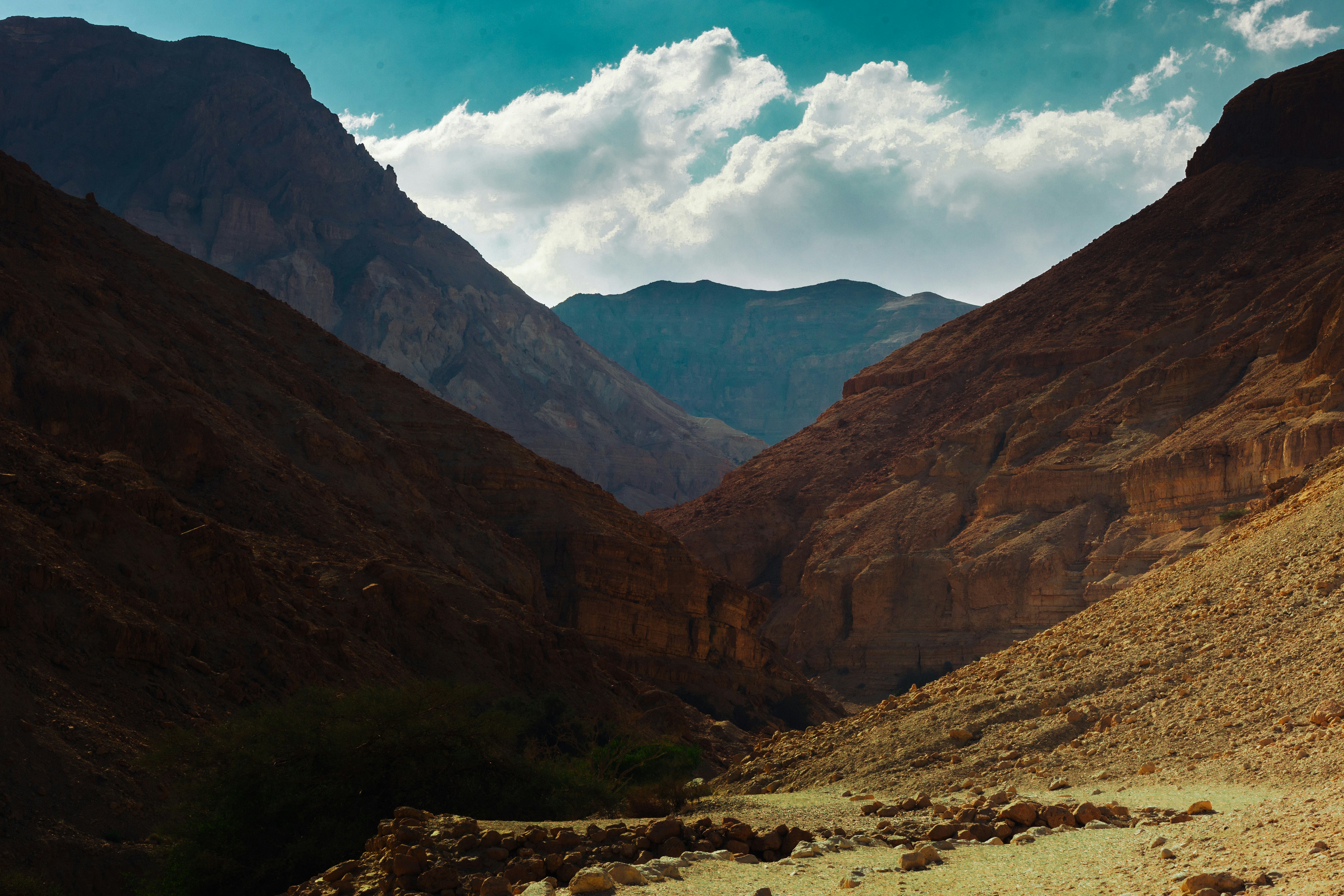 Mountains frame a valley under a partly cloudy sky.