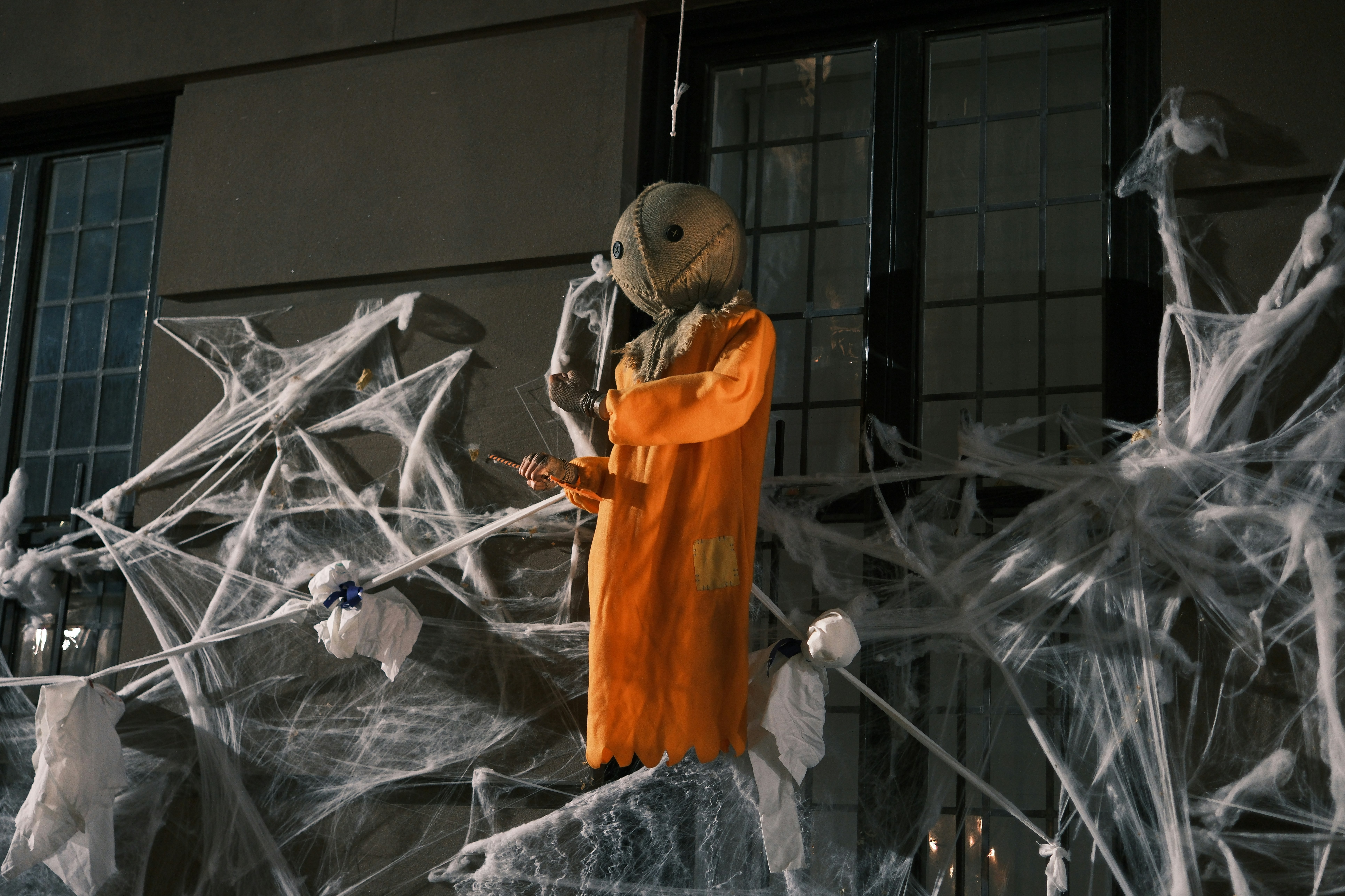 Halloween decoration with hanging figure and cobwebs.