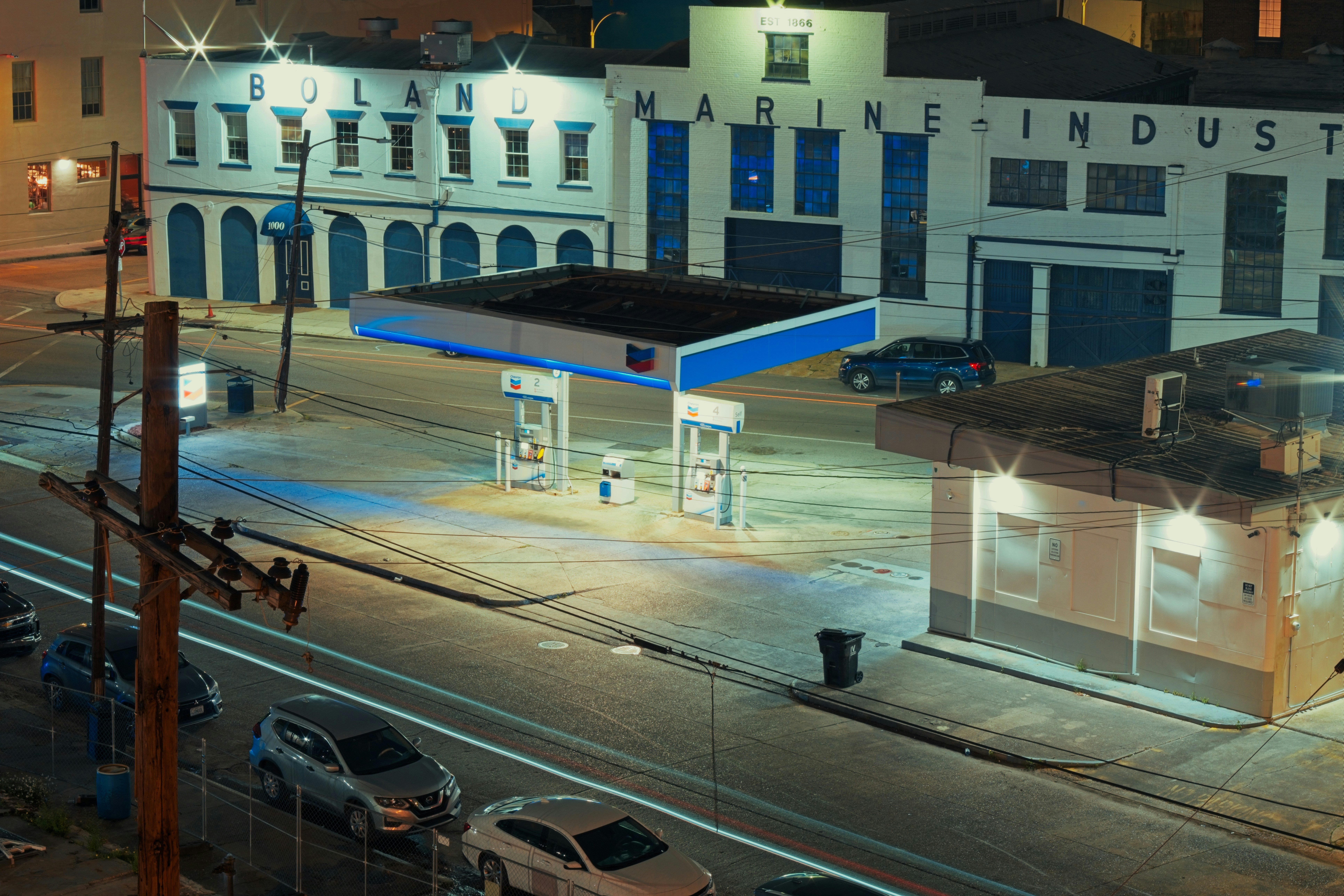 A gas station stands beneath a historic building. photo – Free ...
