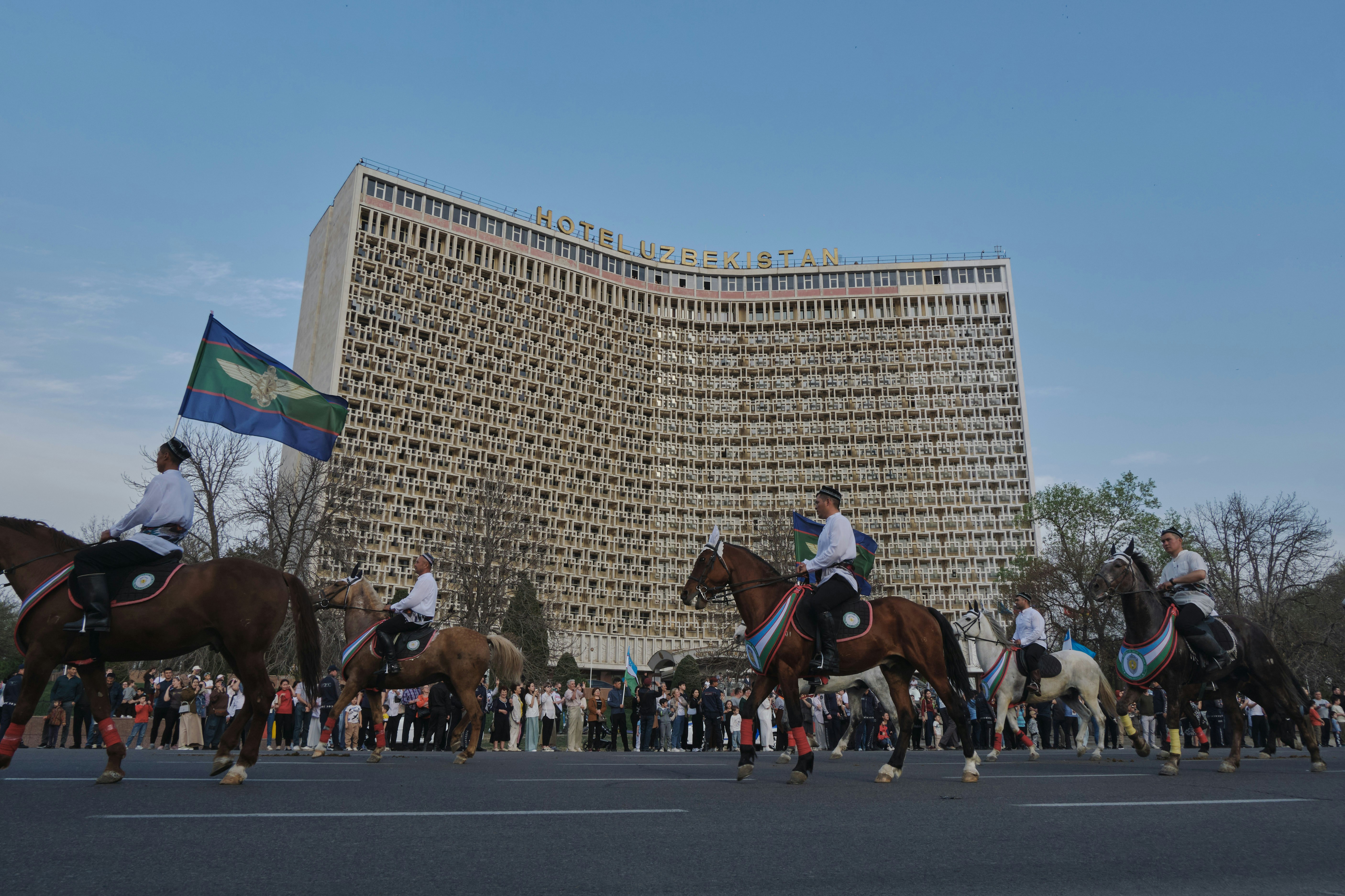 Horse riders parade in front of a large building. photo – Free Human ...