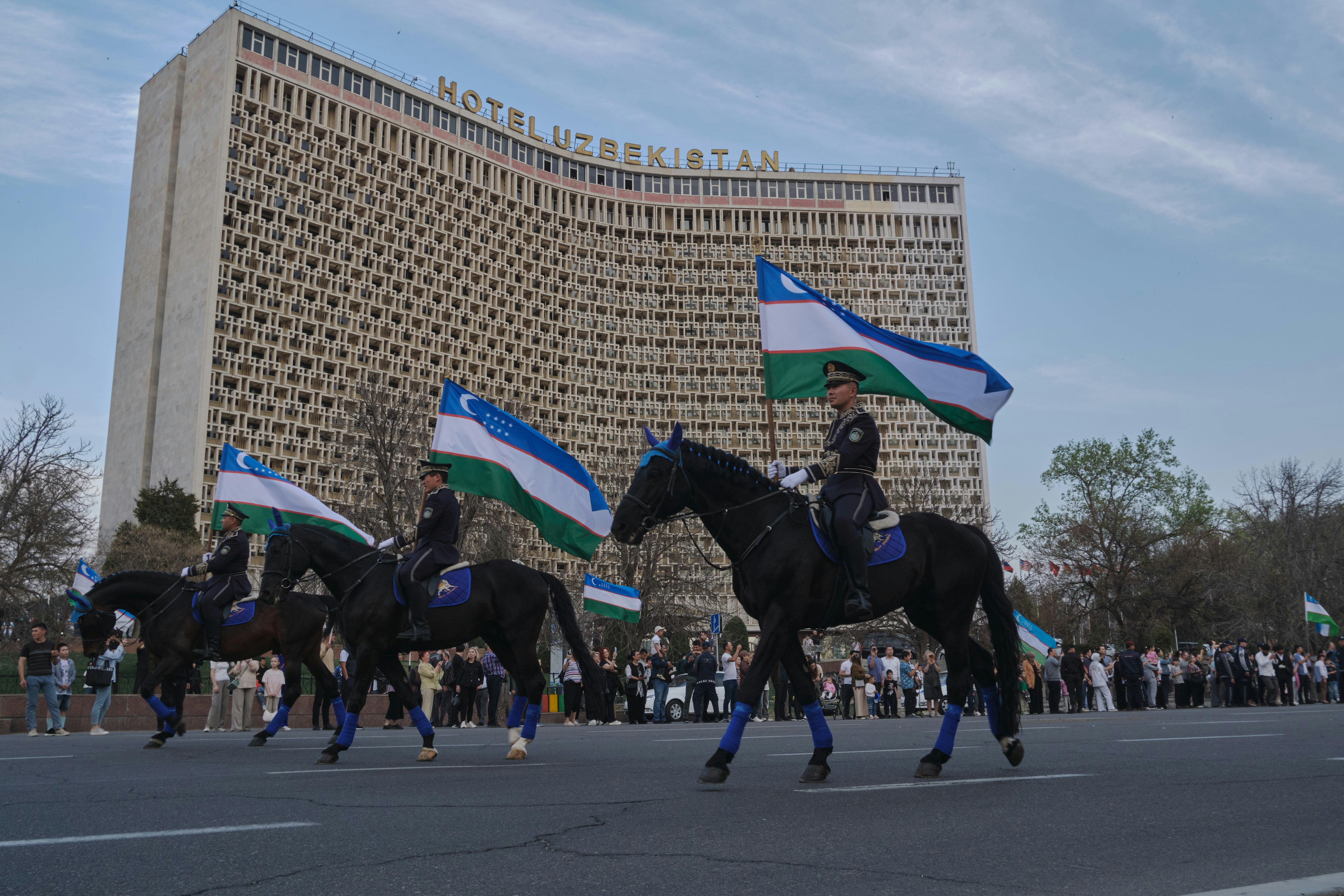 Horseback riders parade with flags near a large building. photo – Free ...