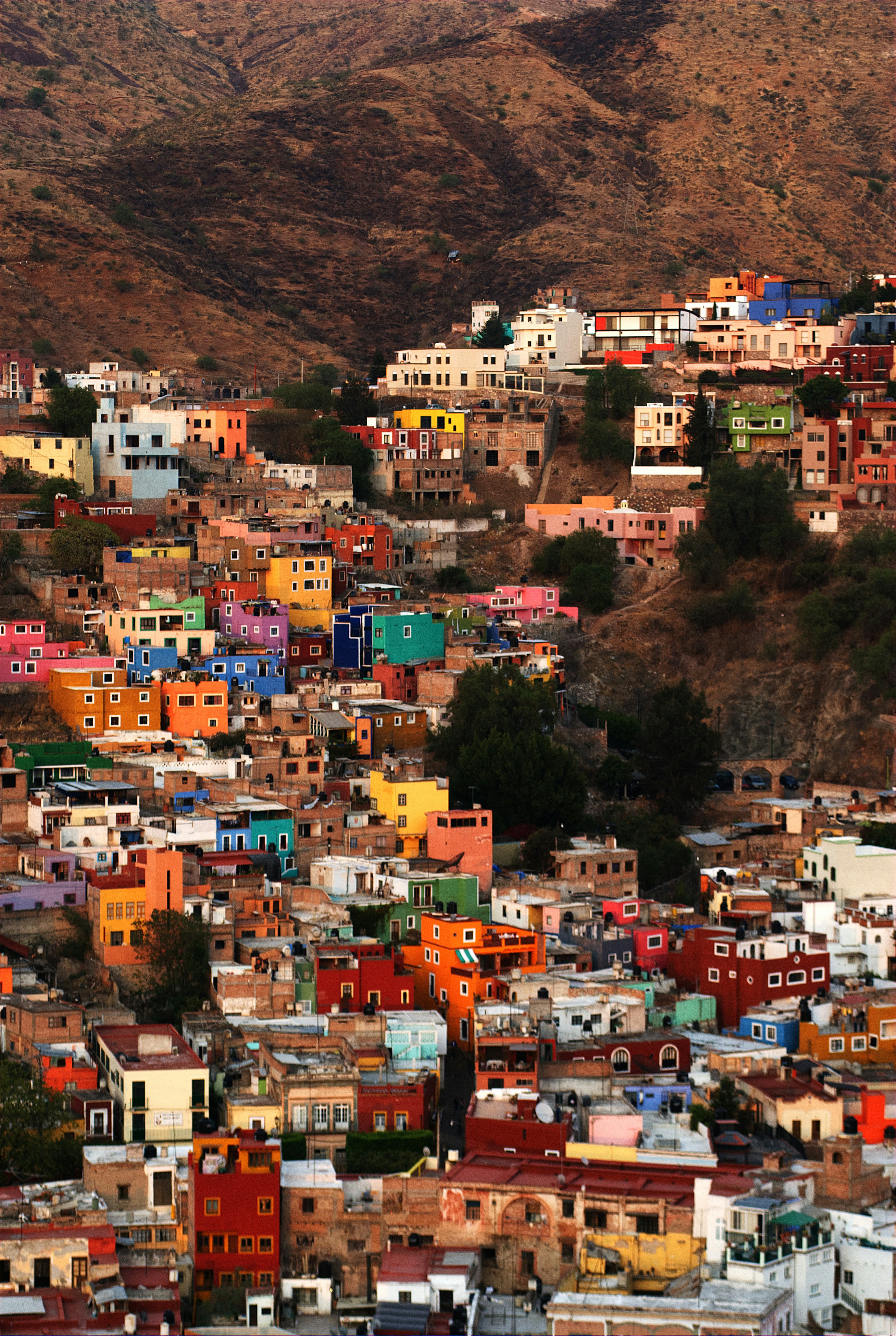 Colorful hillside buildings nestled against a rugged mountain landscape.
