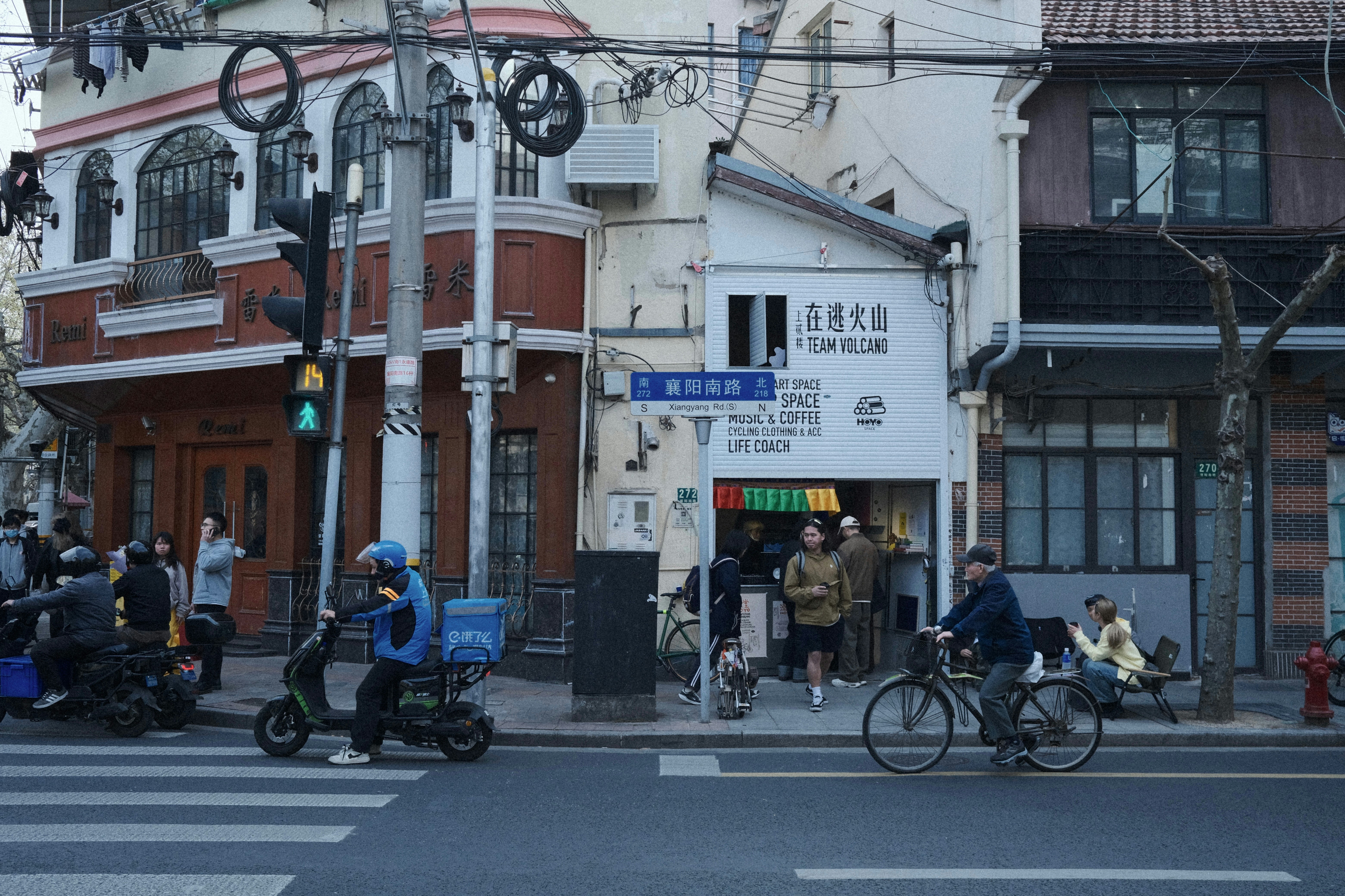 Cyclists and pedestrians navigate a bustling city street lined with diverse architecture.