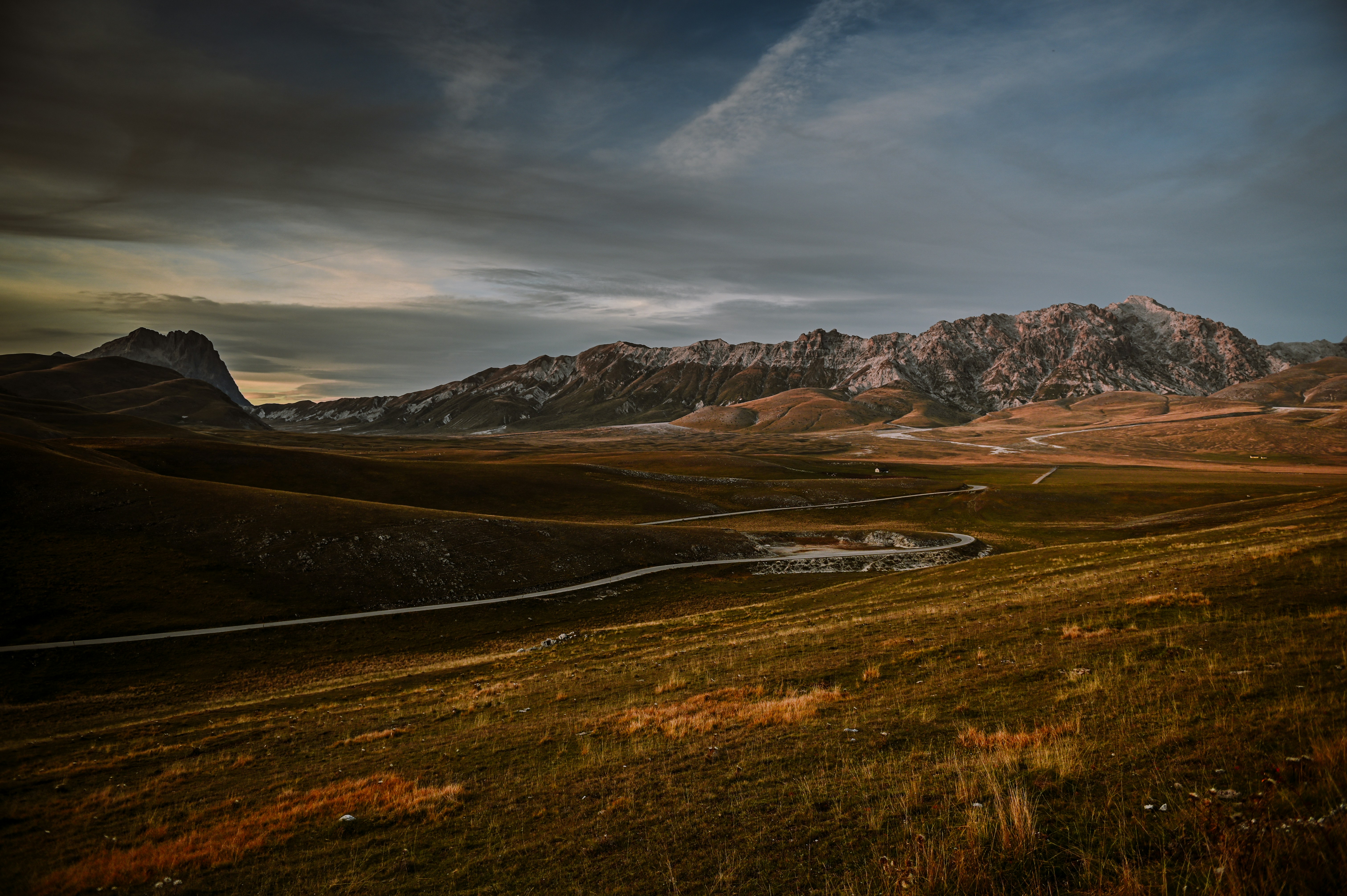 download? 💎 | Rolling hills lead towards majestic mountains.