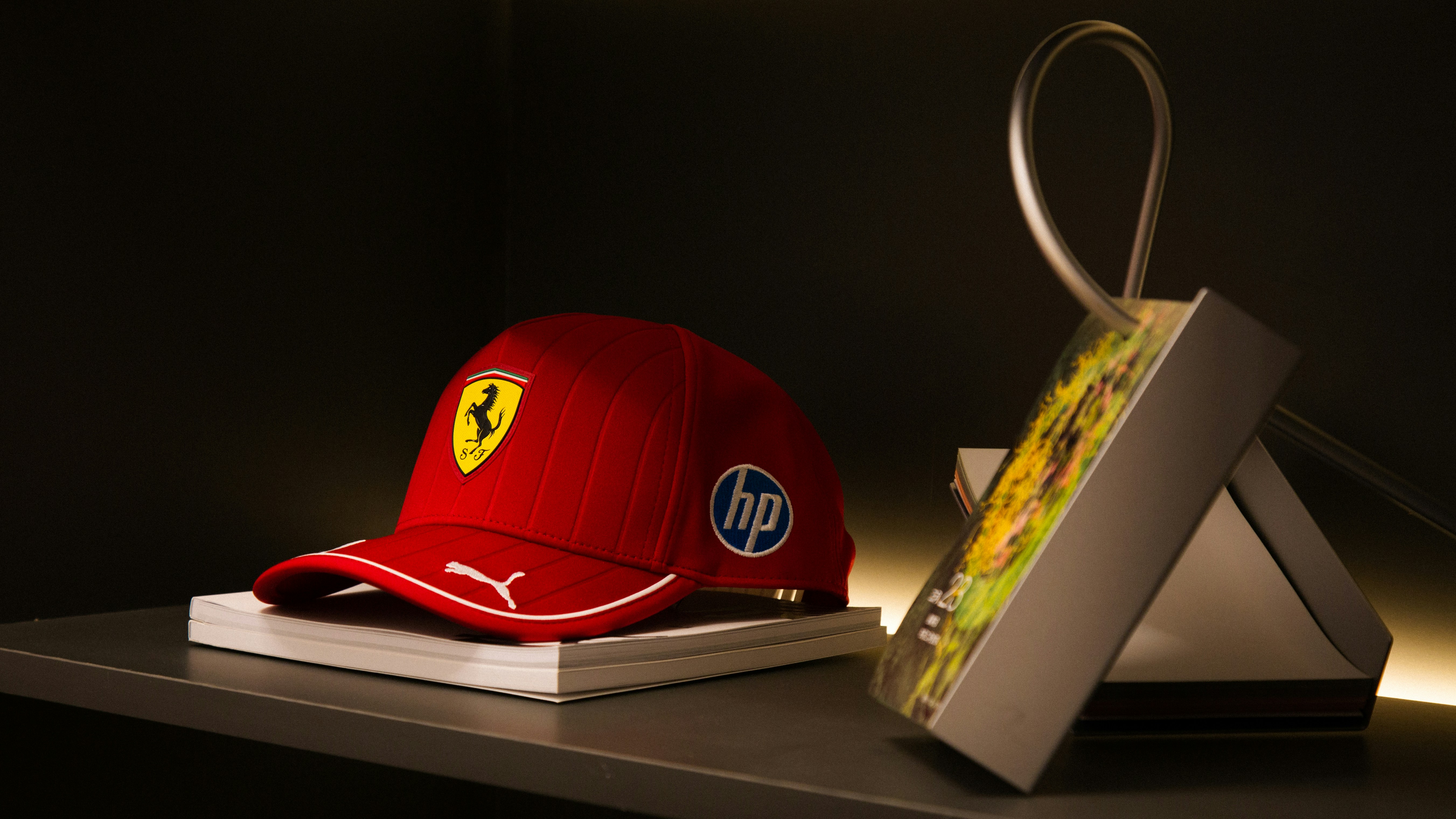 A ferrari cap sits near a display. photo – Free Ferrari Image on Unsplash