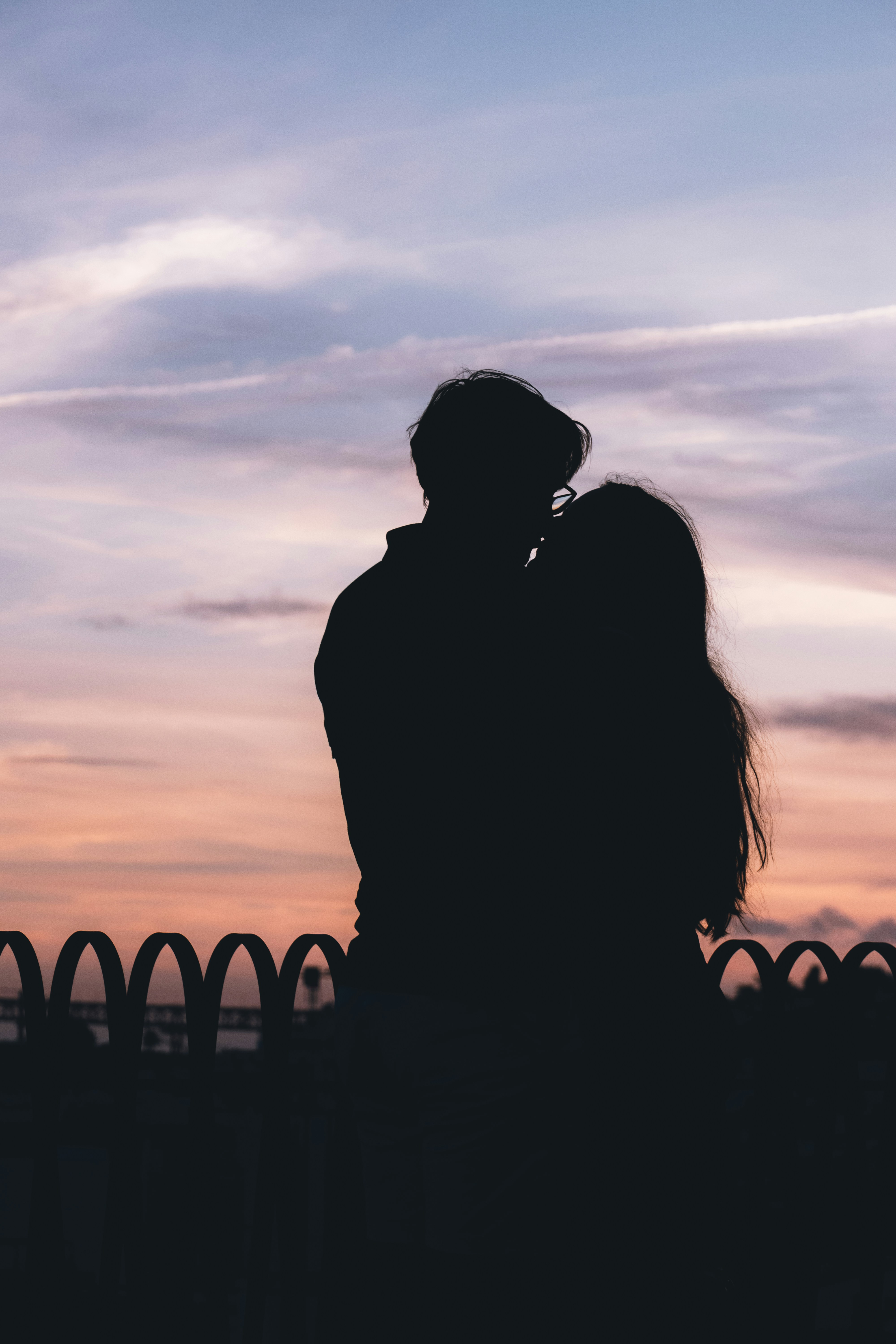 lovers embracing each other on a sunset at miradouro de santa catarina