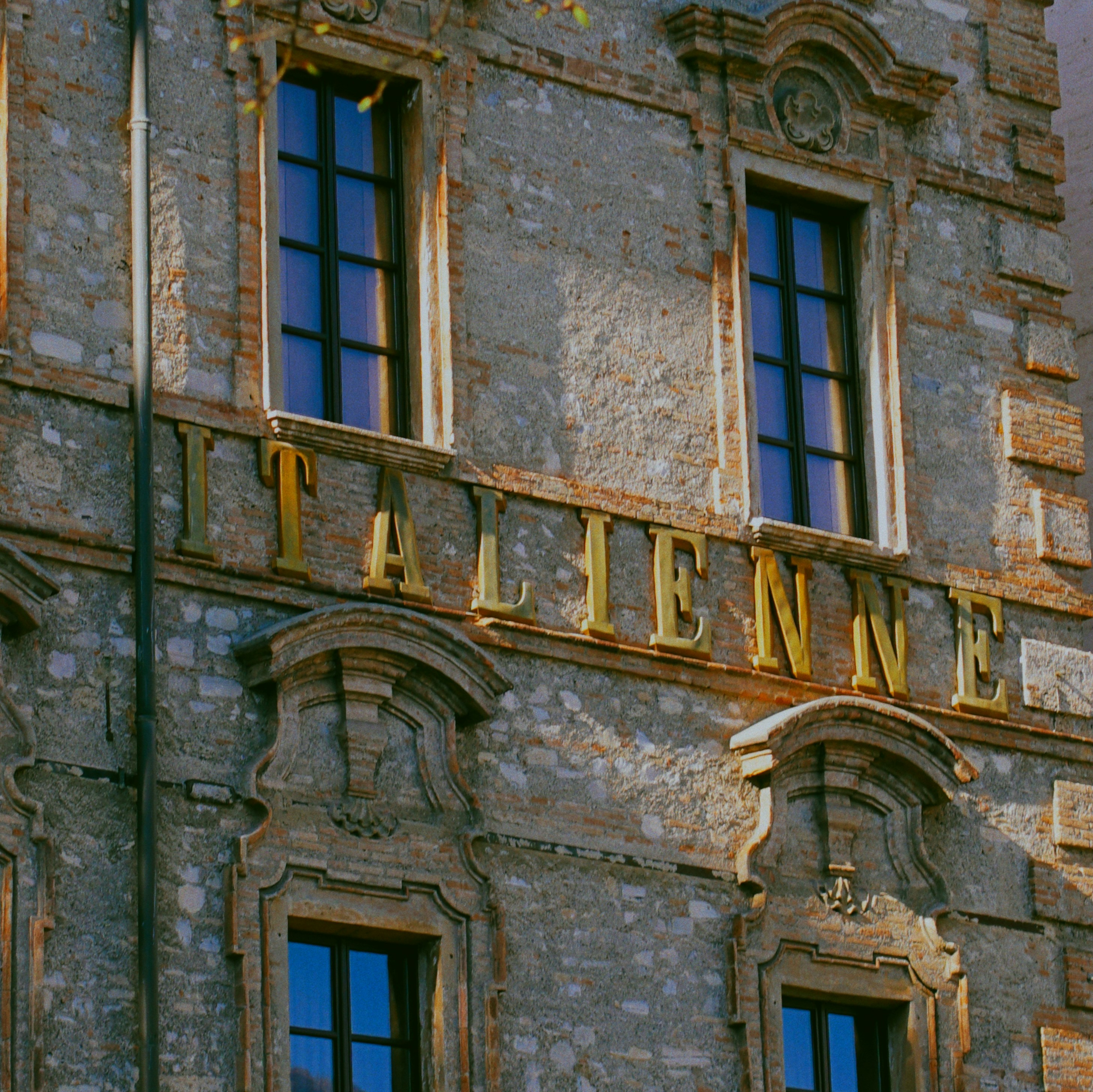 Gilded Letters Crown a Weathered Italian Facade