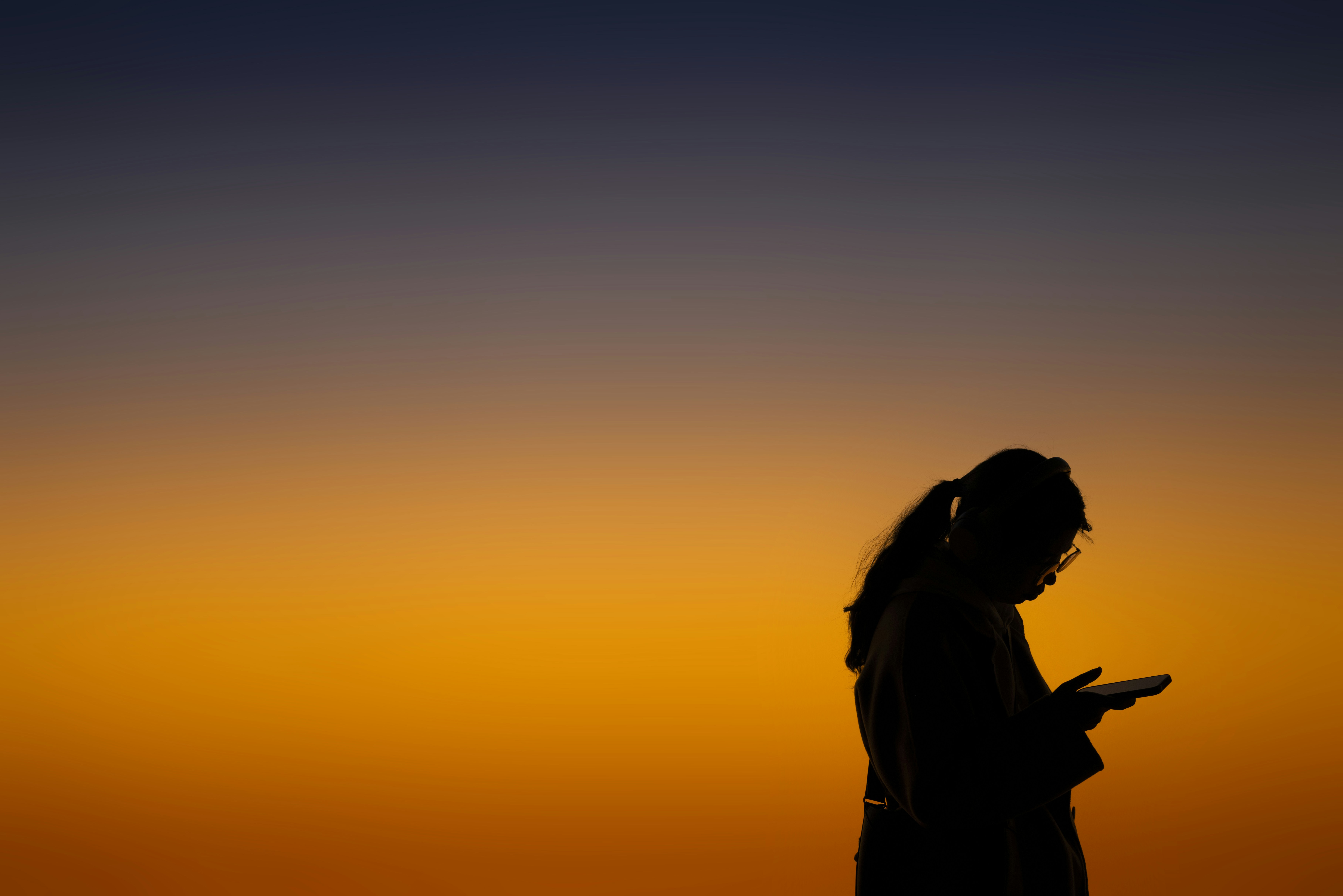Ember Horizon Silhouette: A Quiet Moment with a Glowing Screen