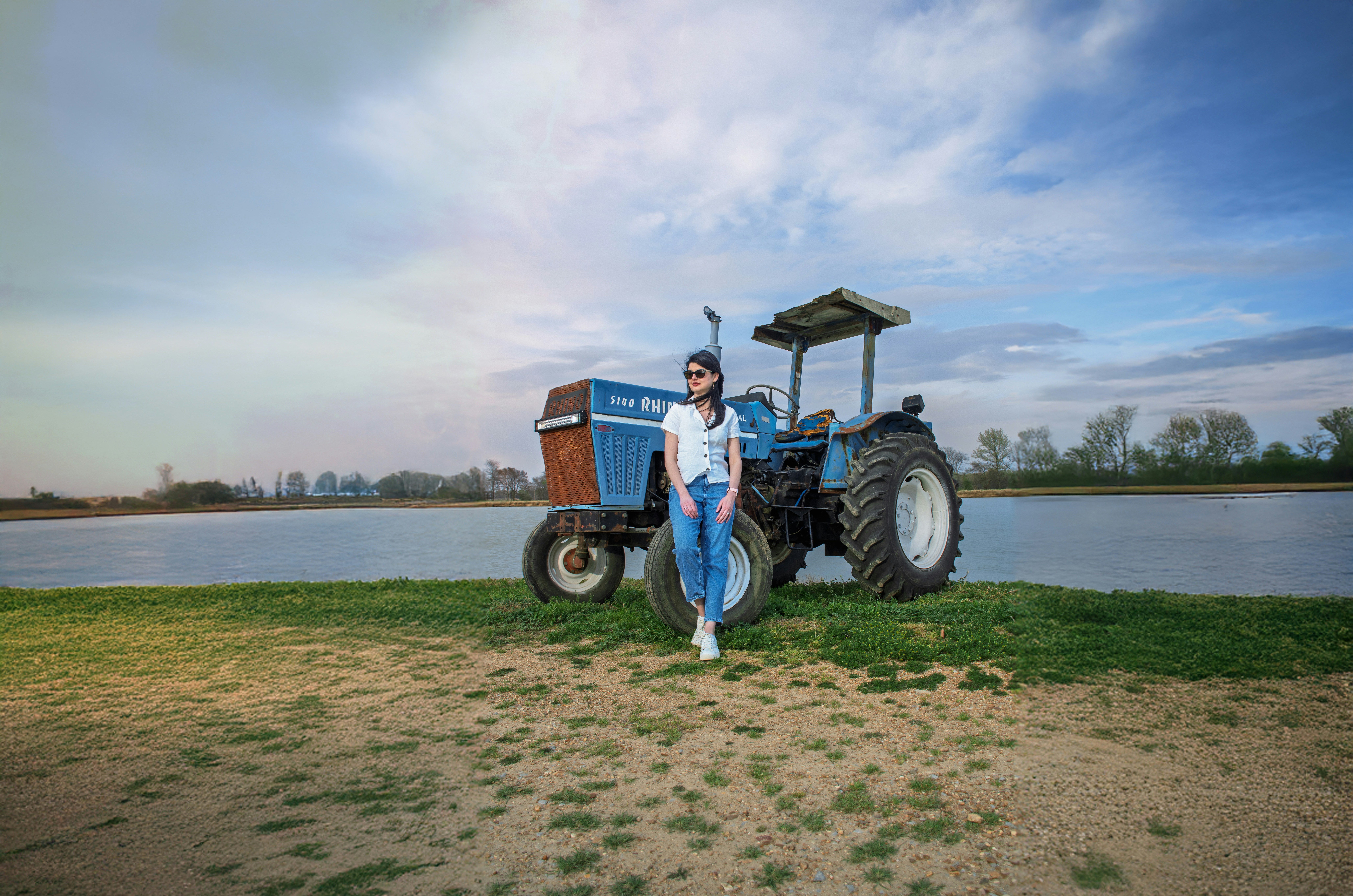 Woman poses next to a blue tractor. photo – Free Image on Unsplash
