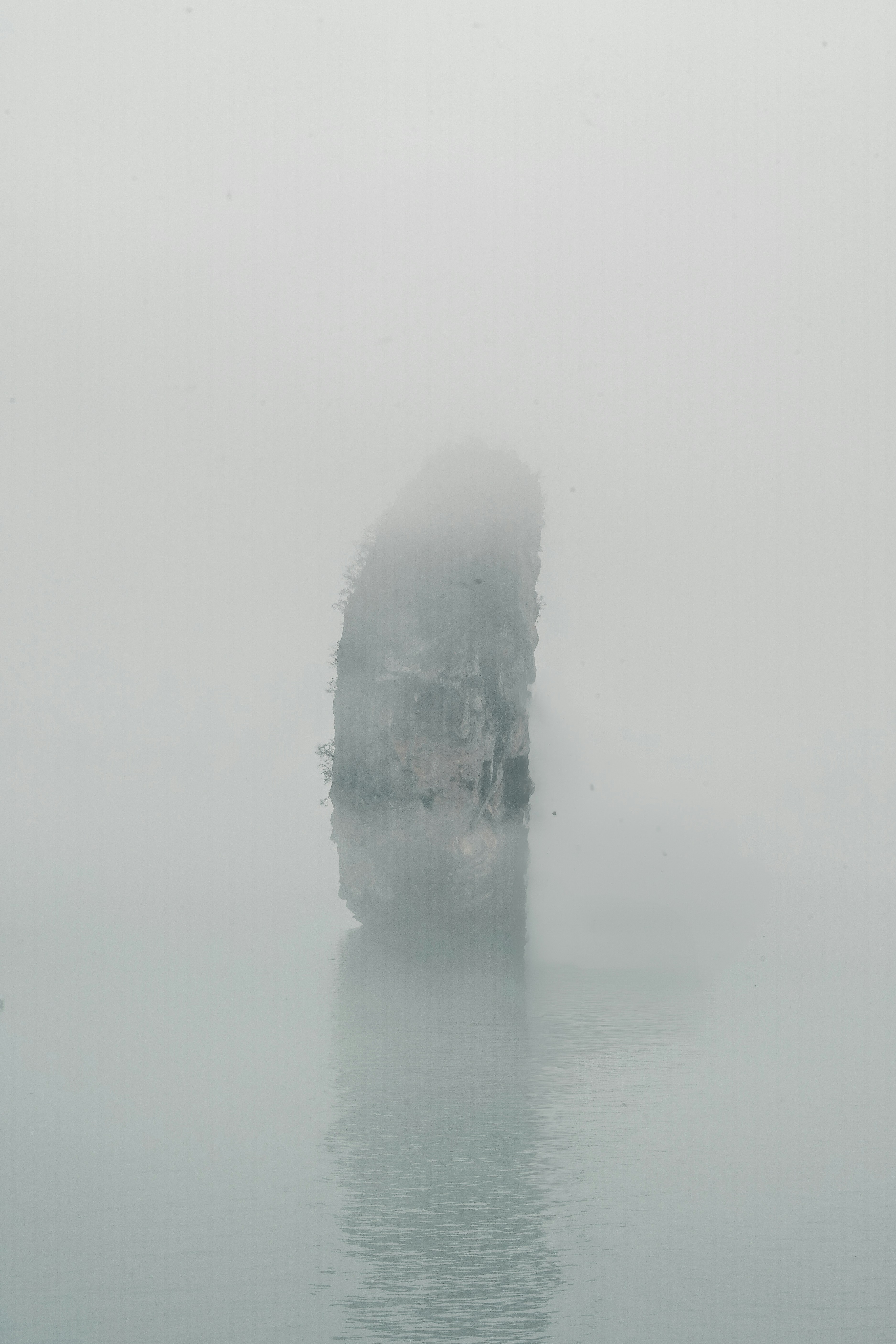 Mistbound Monolith: A Lone Pillar Rising from Fjord Fog