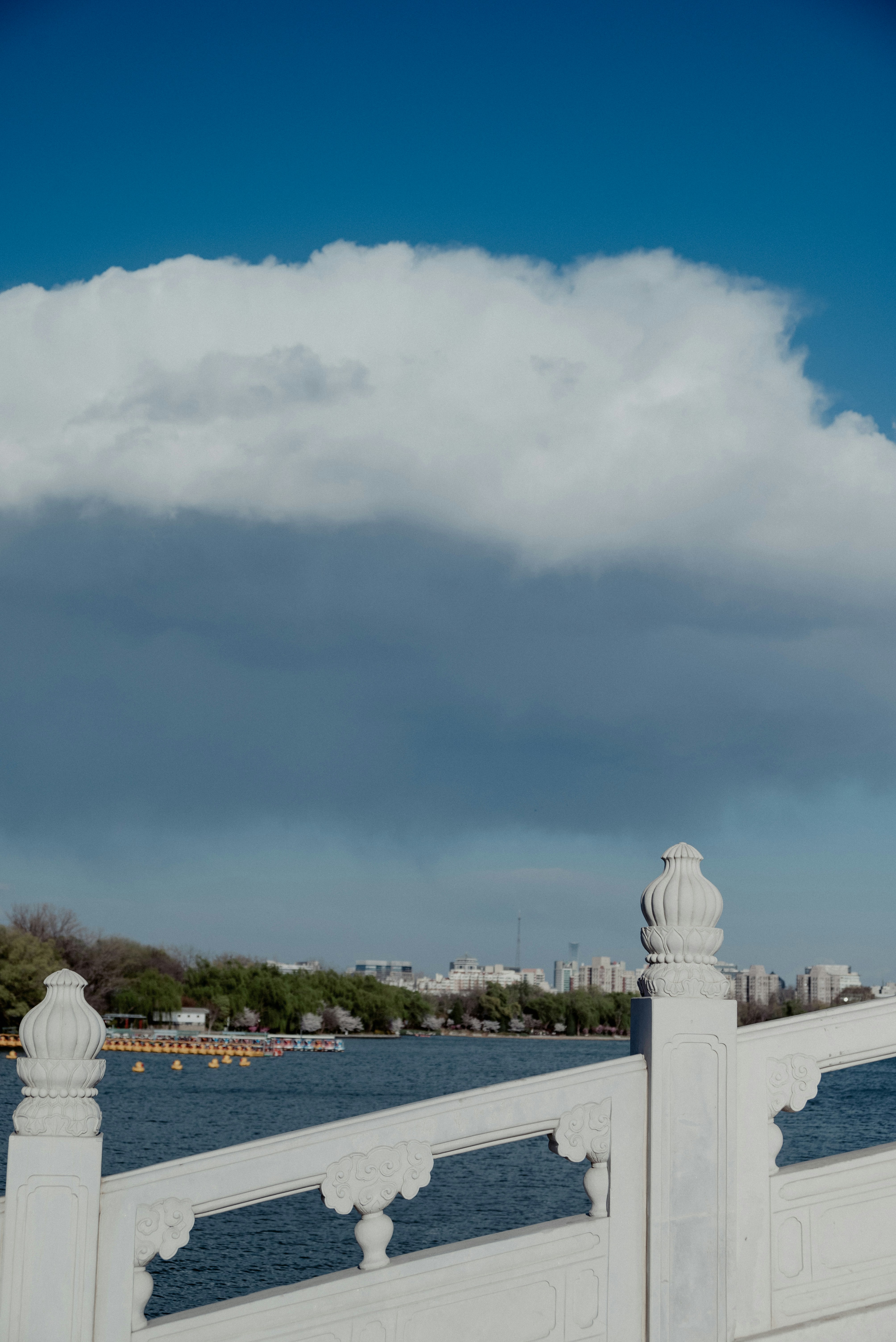 White railing and distant city under a looming cloudbank