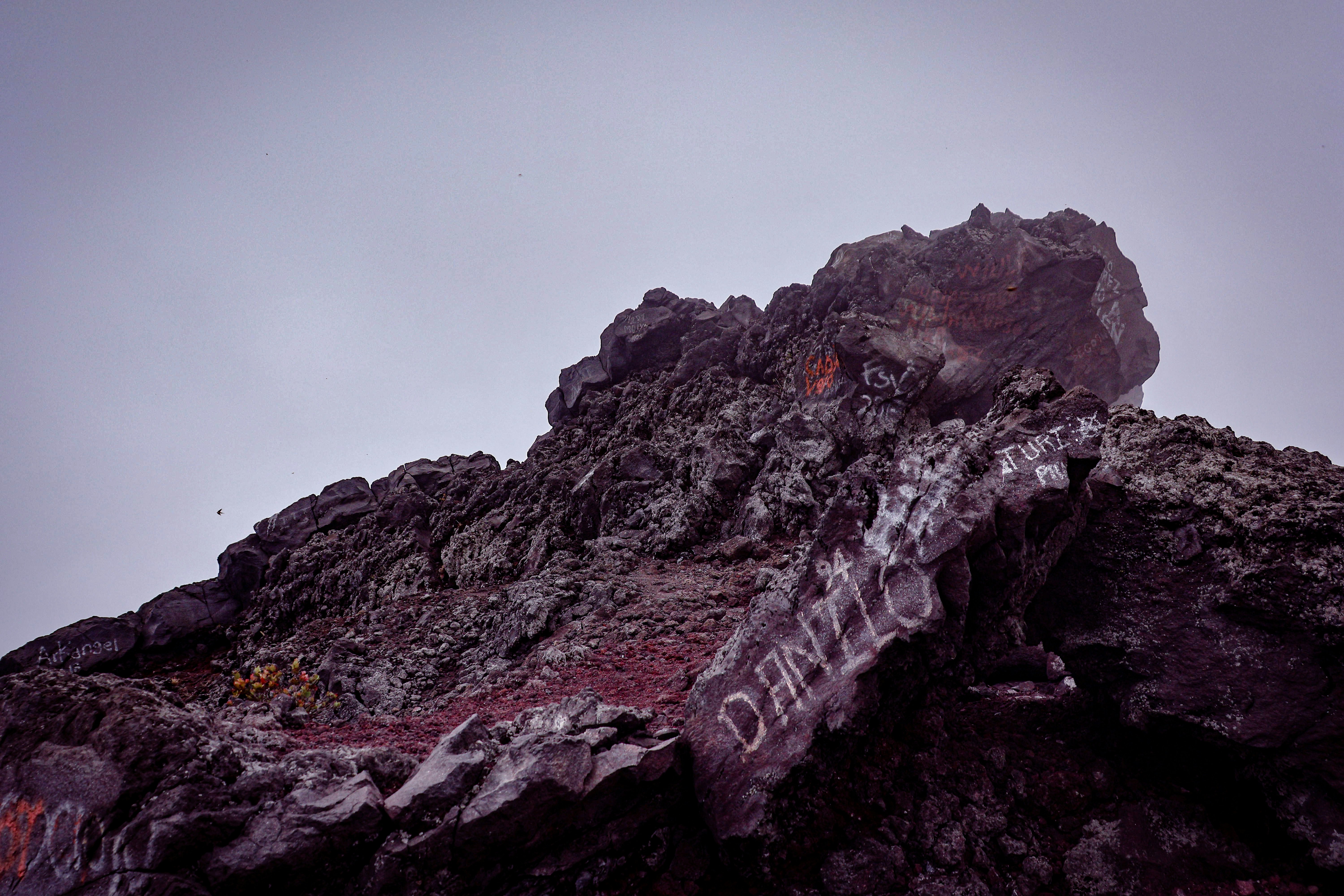 Dark, jagged rock formation with graffiti on it. photo – Free Volcano ...