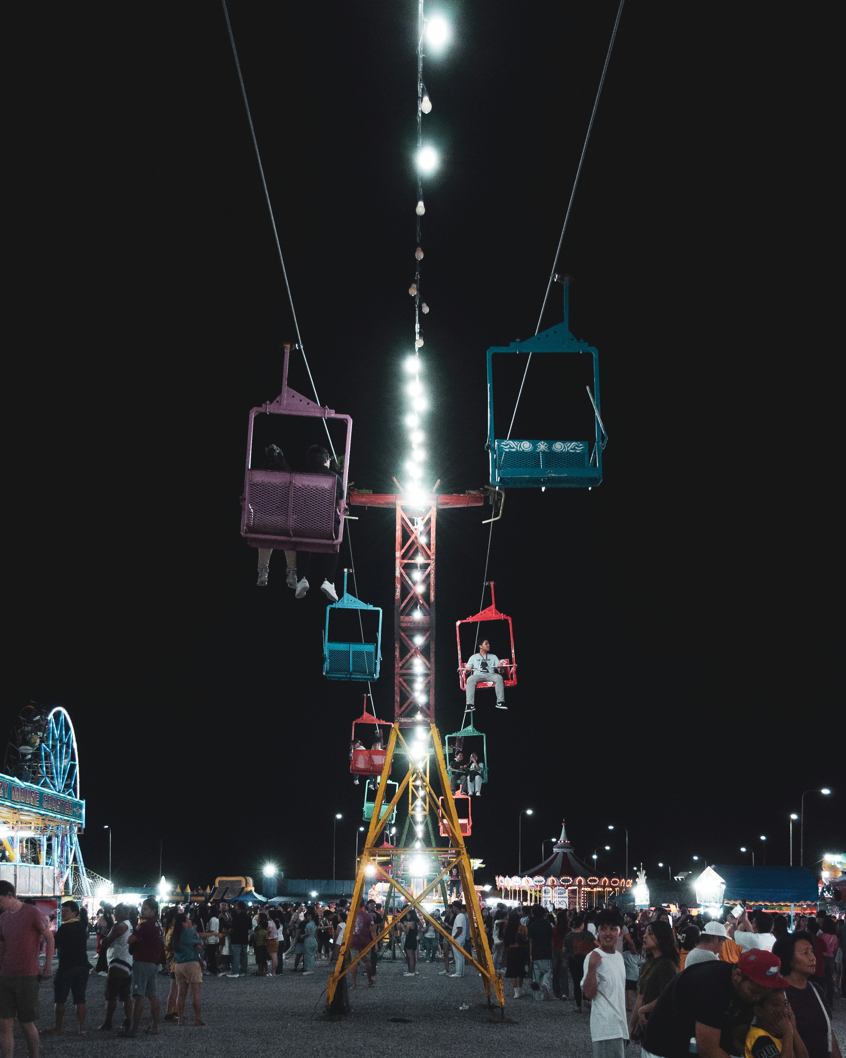 Midnight Lift: Neon Carriages Hover over a Crowded Fairground