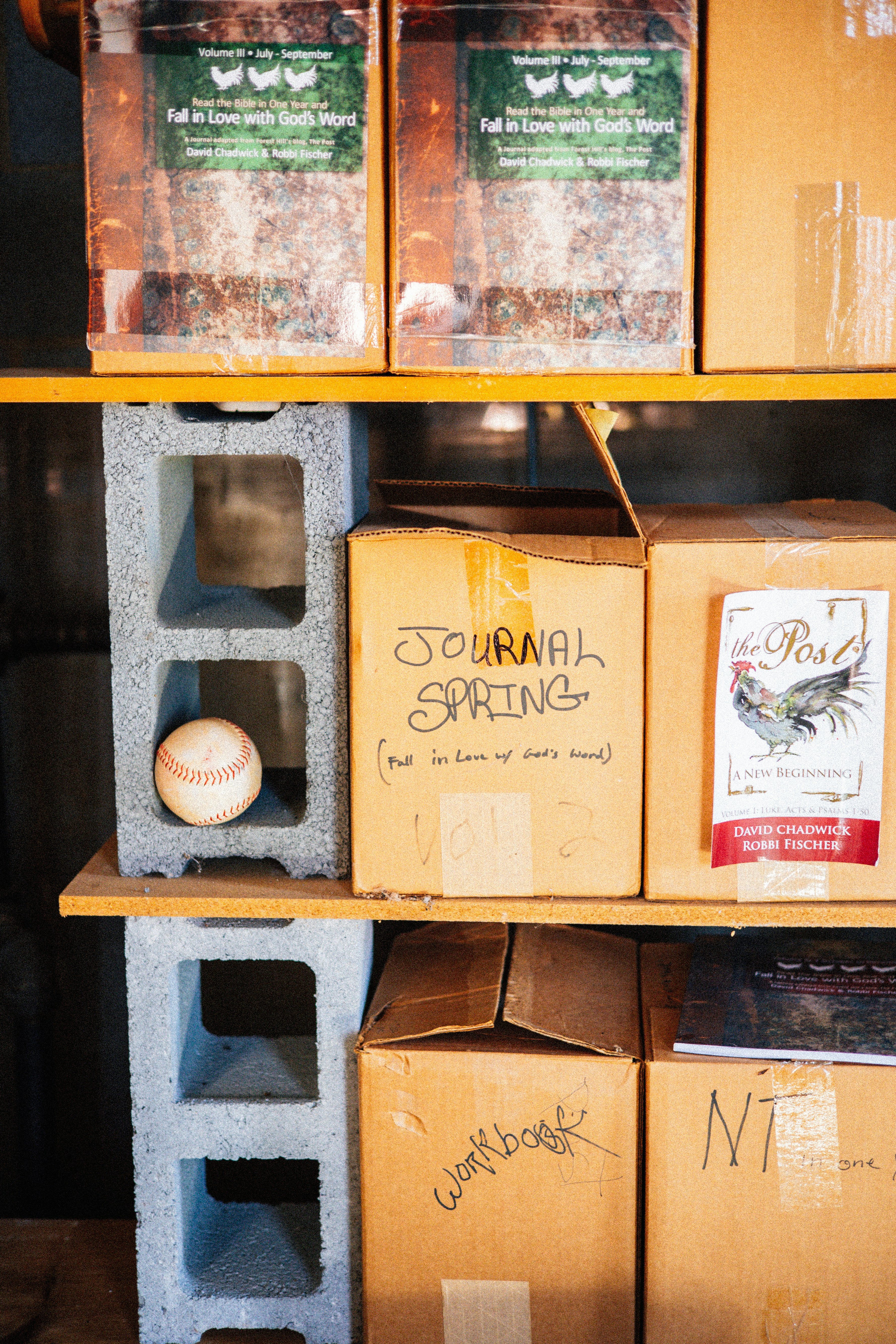 Baseball in a Cinder Block Nook Amid Cardboard Shelves