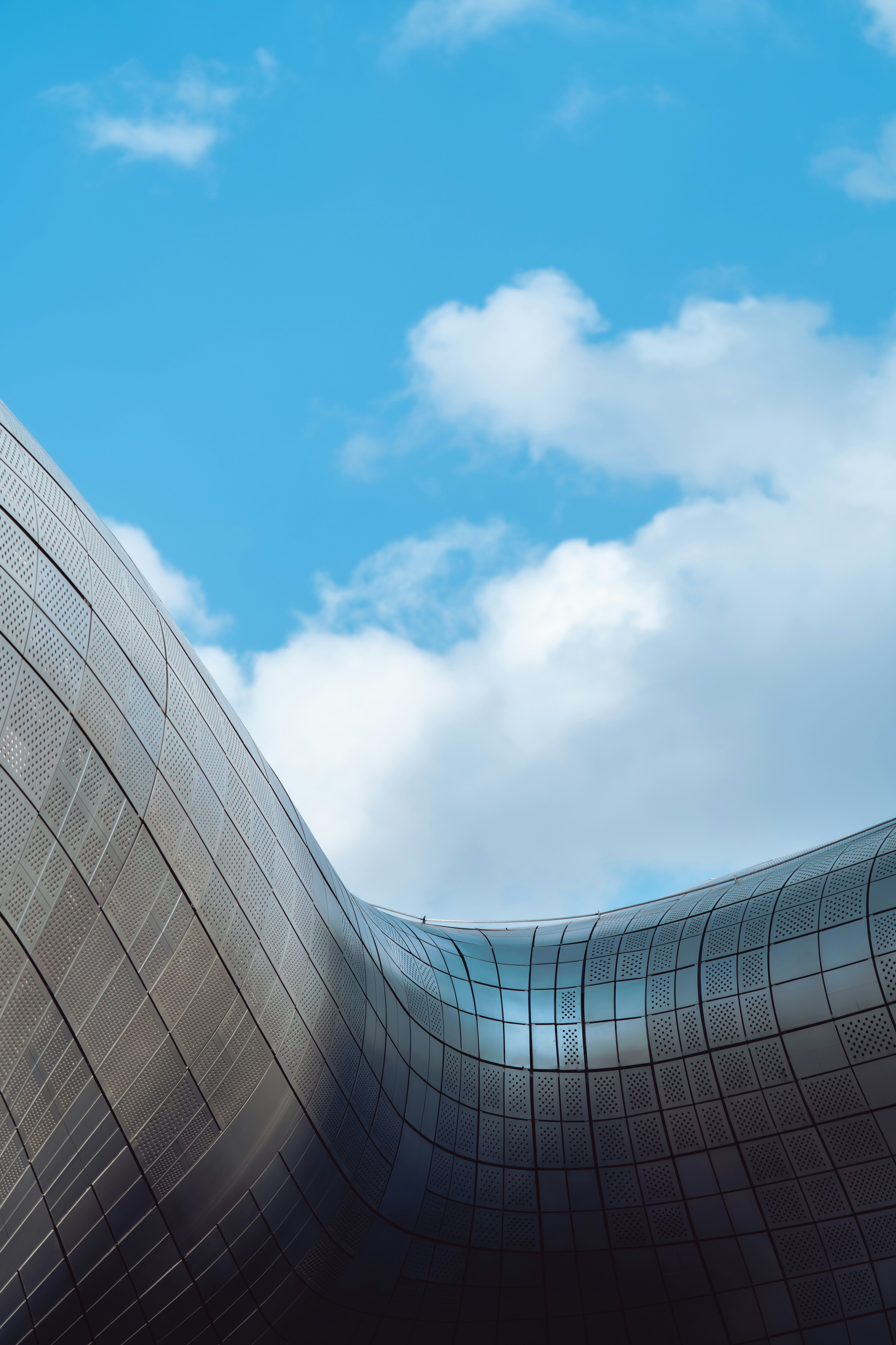 A modern building curves gracefully against the blue sky. photo – Free ...