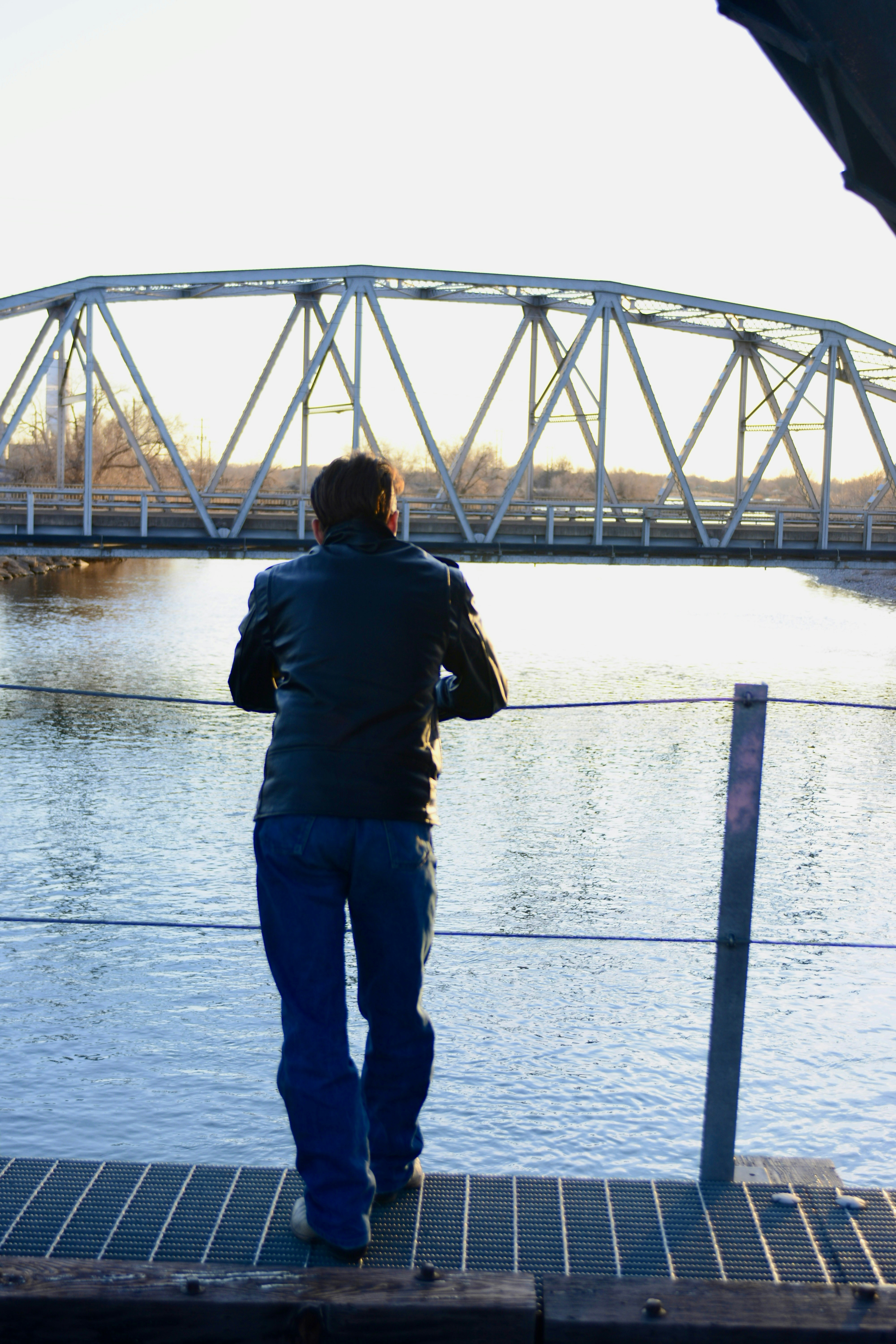 A man views a bridge over water. photo – Free Portrait Image on Unsplash
