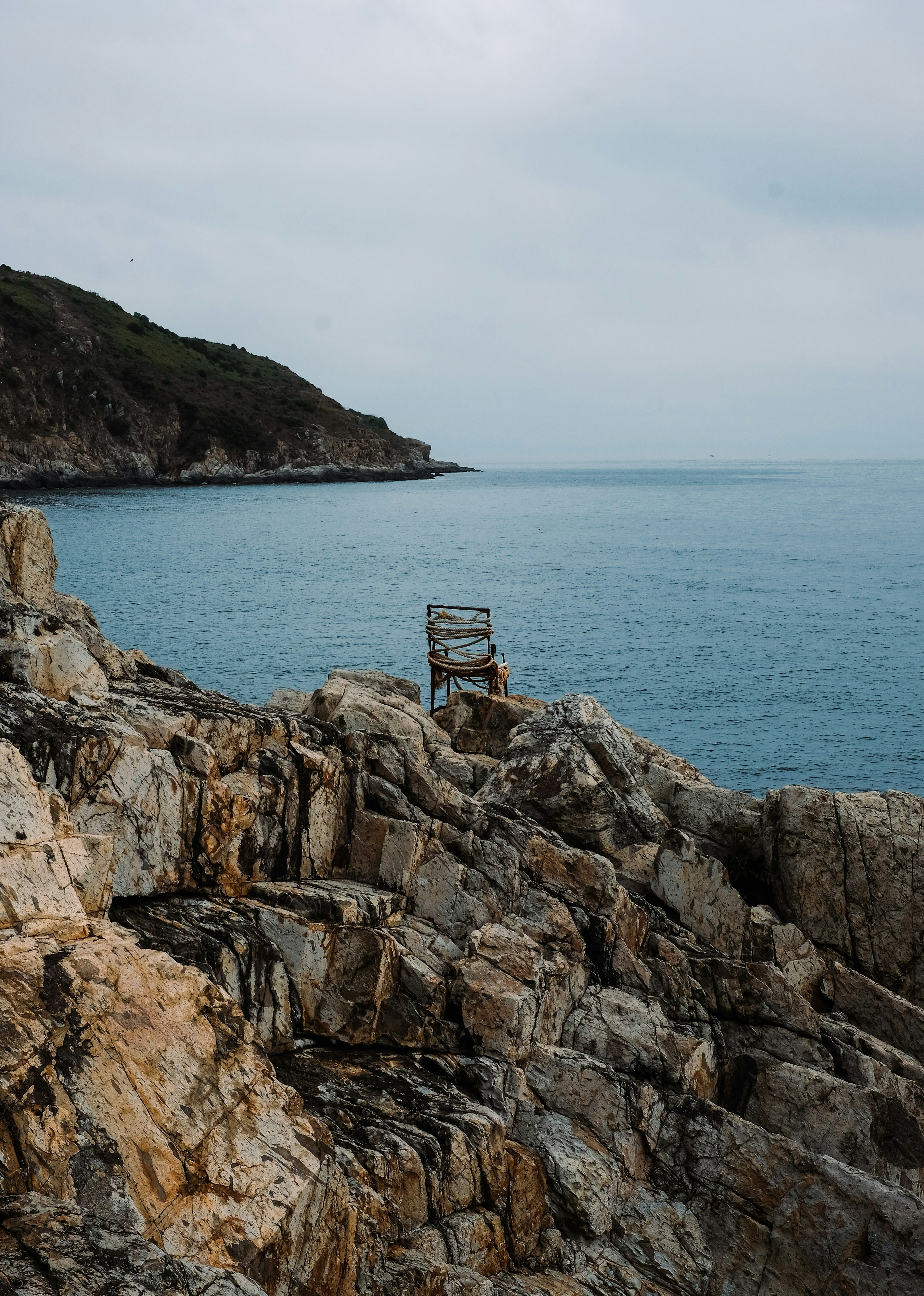 Rugged Promenade: A lone chair Defiantly Crowned by Crags