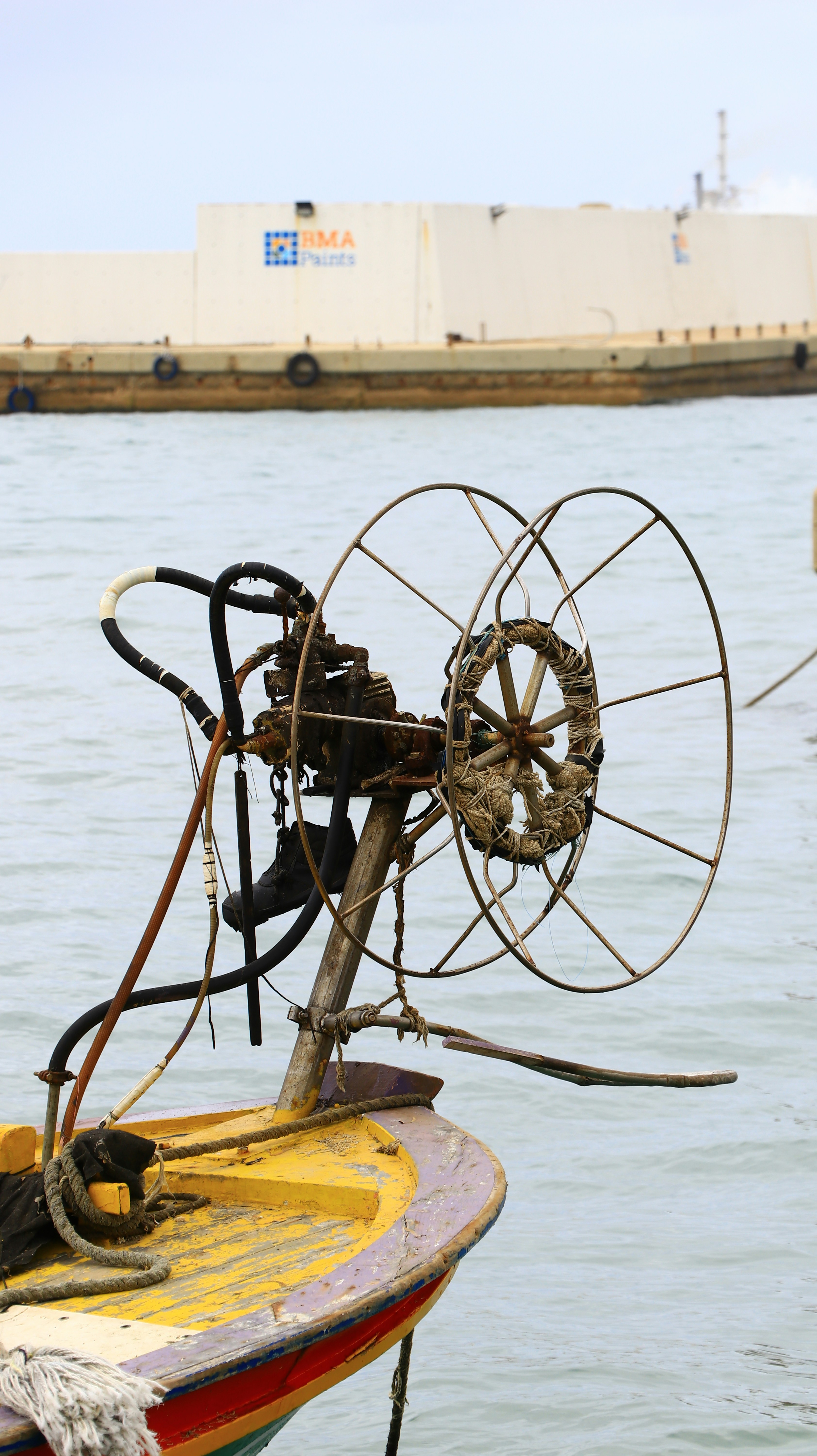 Spoked Relic at the Bow: a Weathered Reel Guarding the Harbor