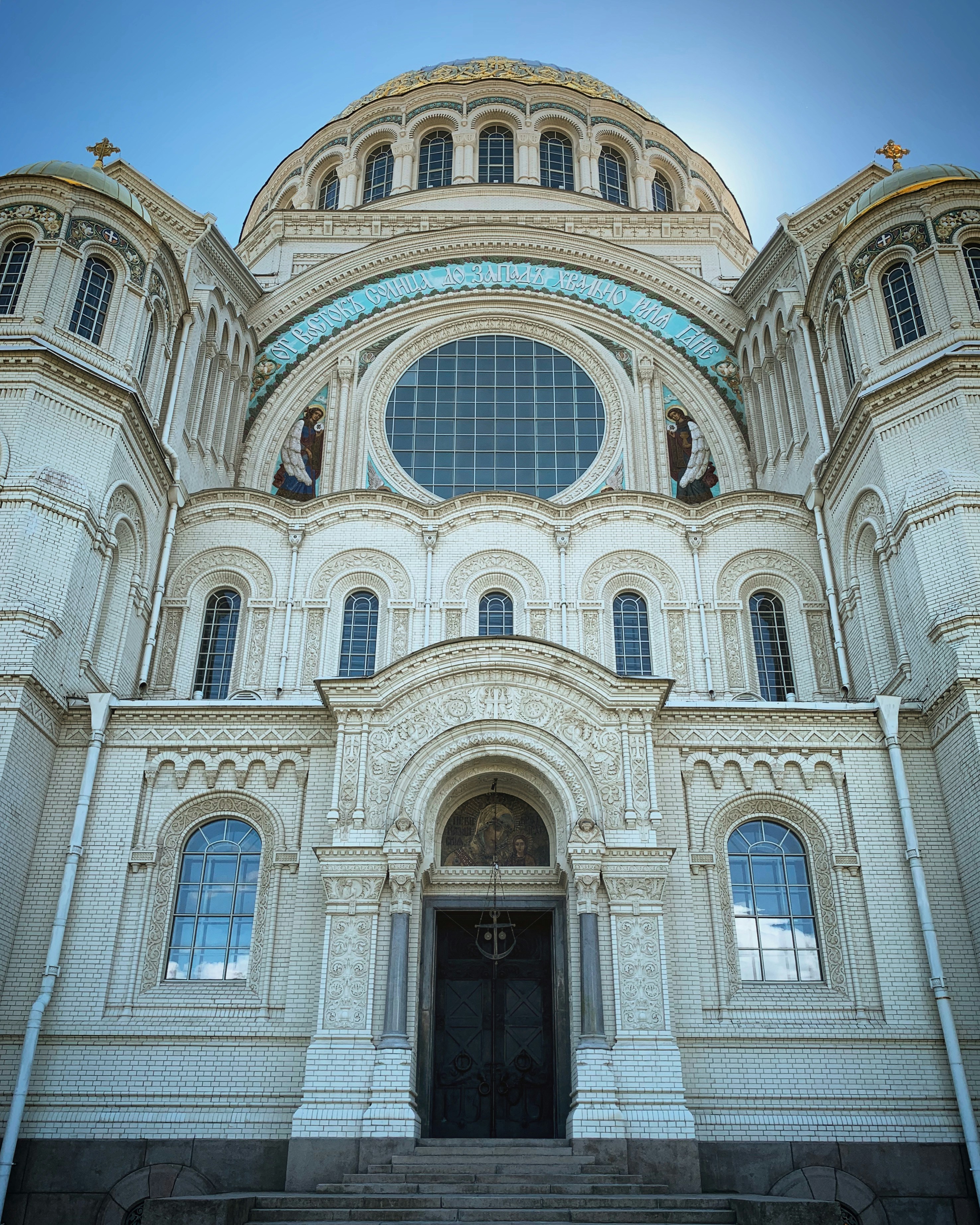 Imposing entrance of the Naval Cathedral of Saint Nicholas with intricate architectural details under a clear blue sky.