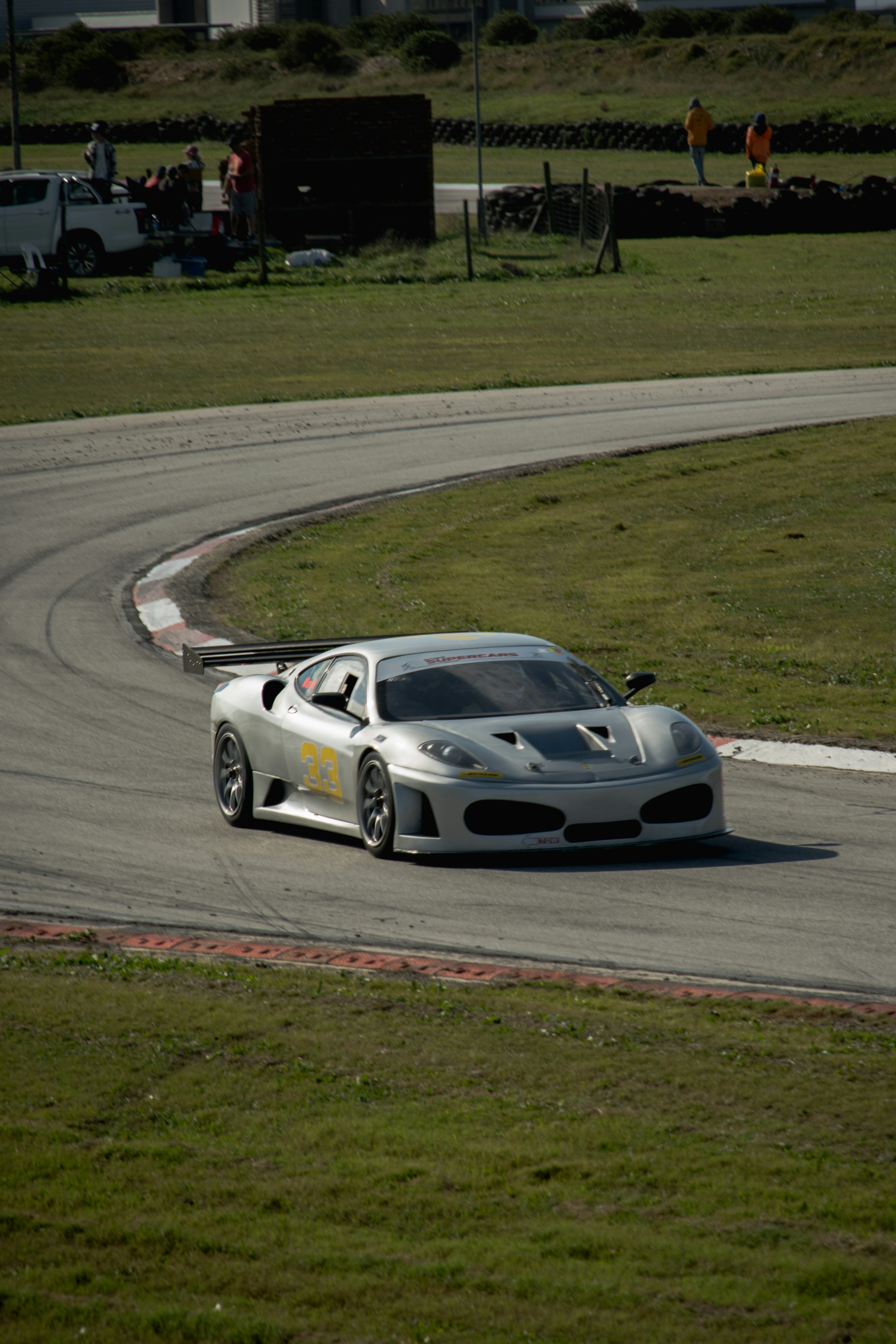 Un Ferrari plateado corre alrededor de la curva de una pista. foto ...