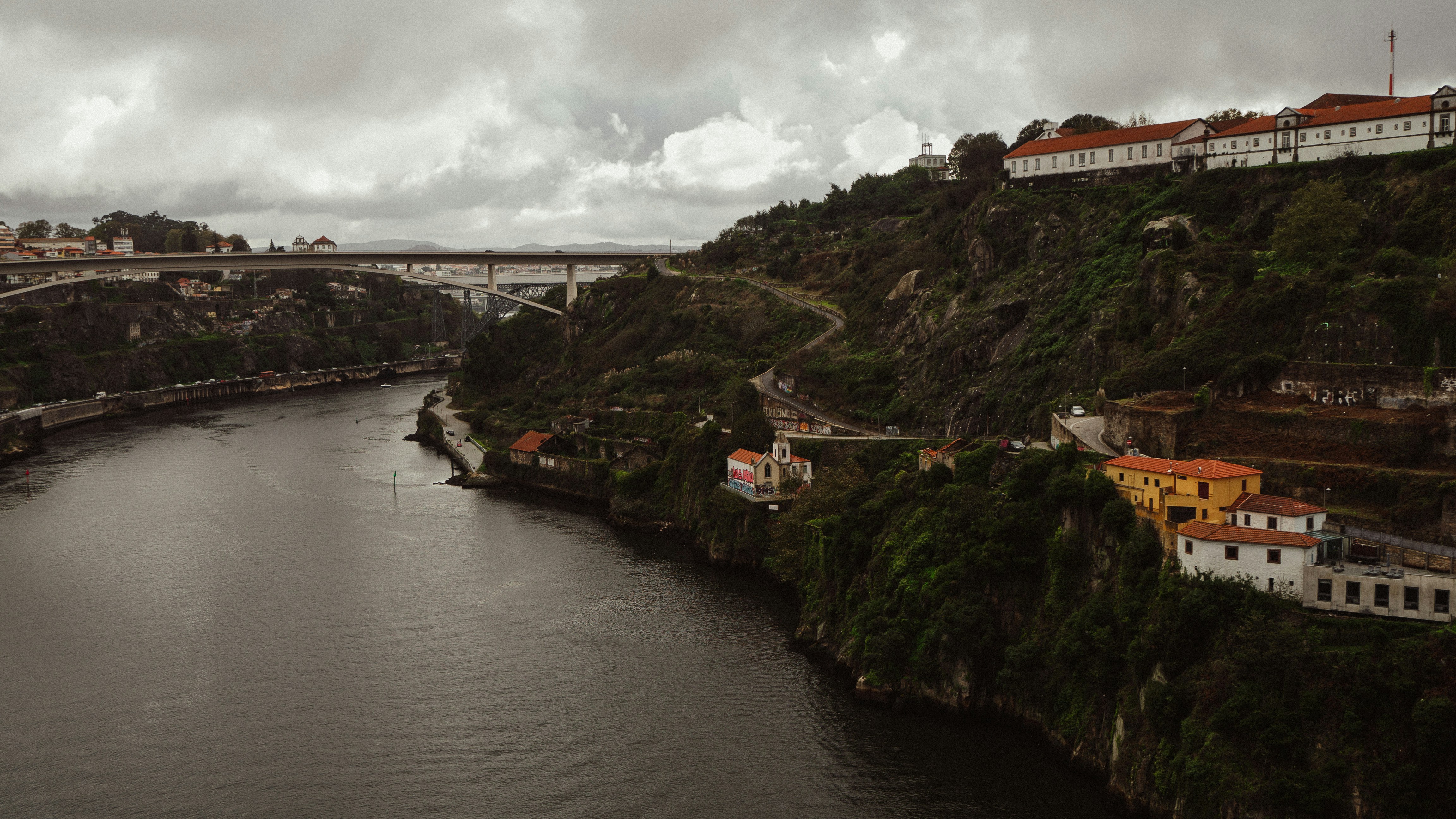 A bridge spans a river on a gloomy day.