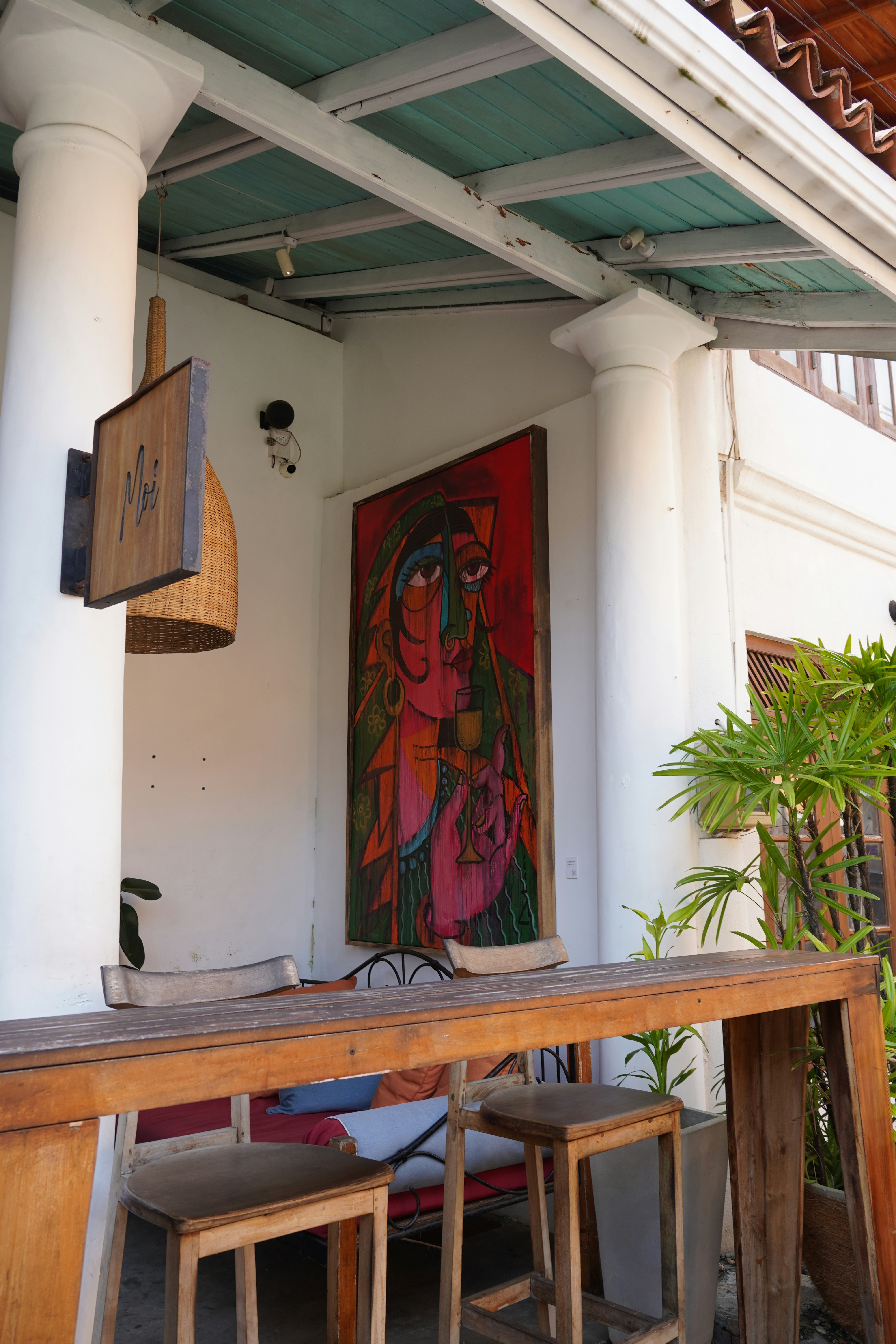 Abstract Portrait on a Sunny Veranda: Colorful Wall Art Framed by White Columns