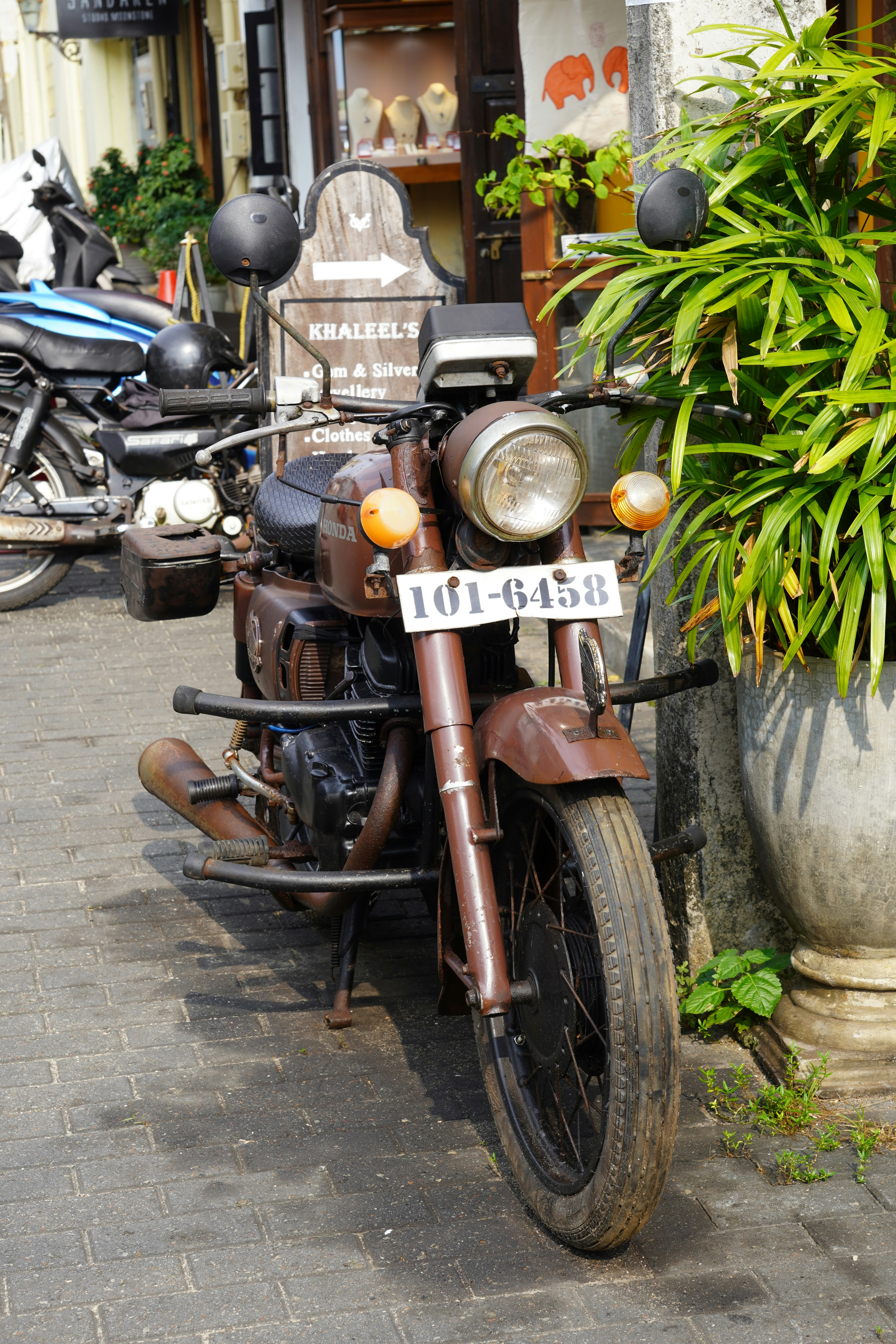 Front and Center: A Vintage Brown Motorcycle Anchors a Cobblestone Street