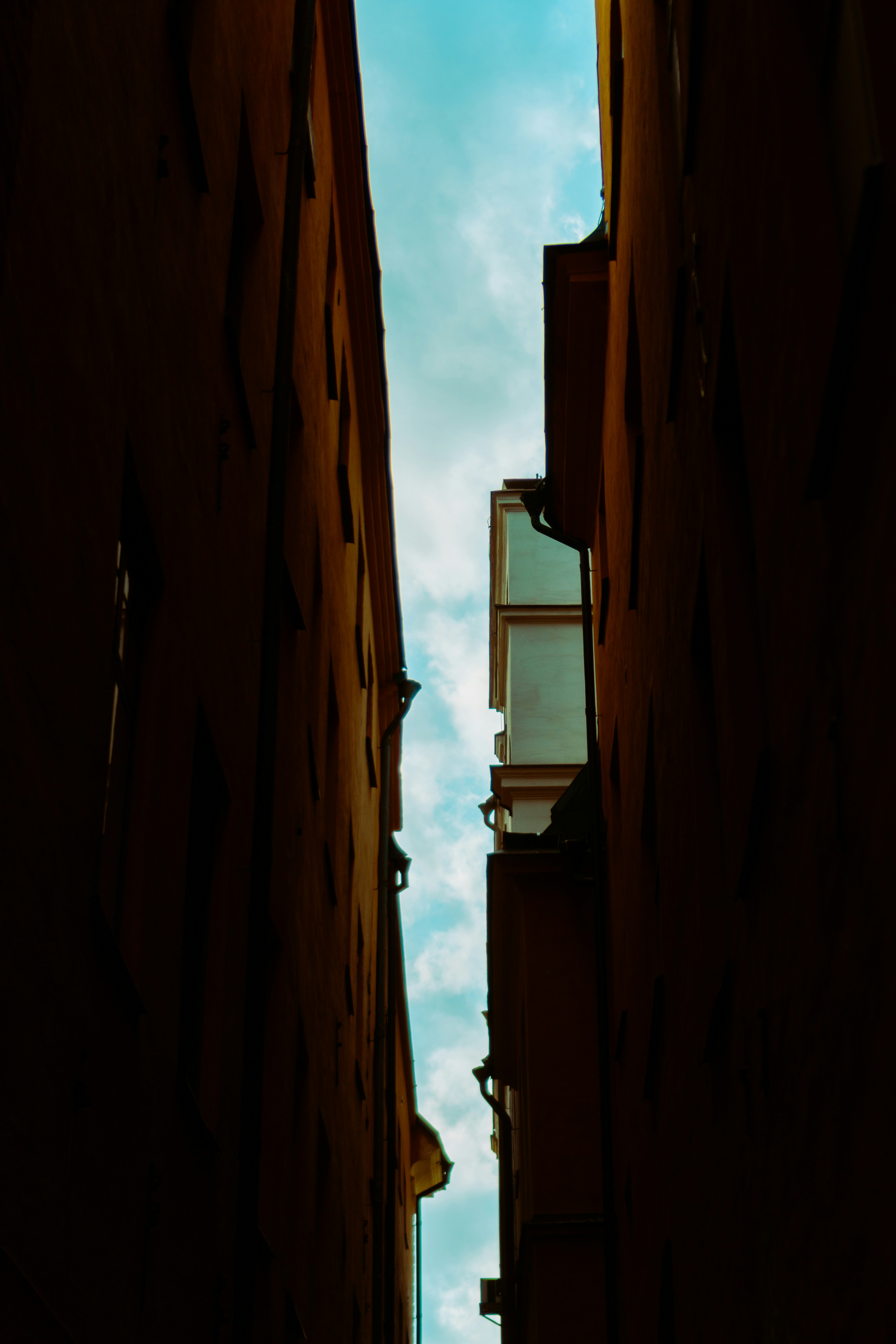 Sky peeks through buildings in a narrow alley. photo – Free Building ...