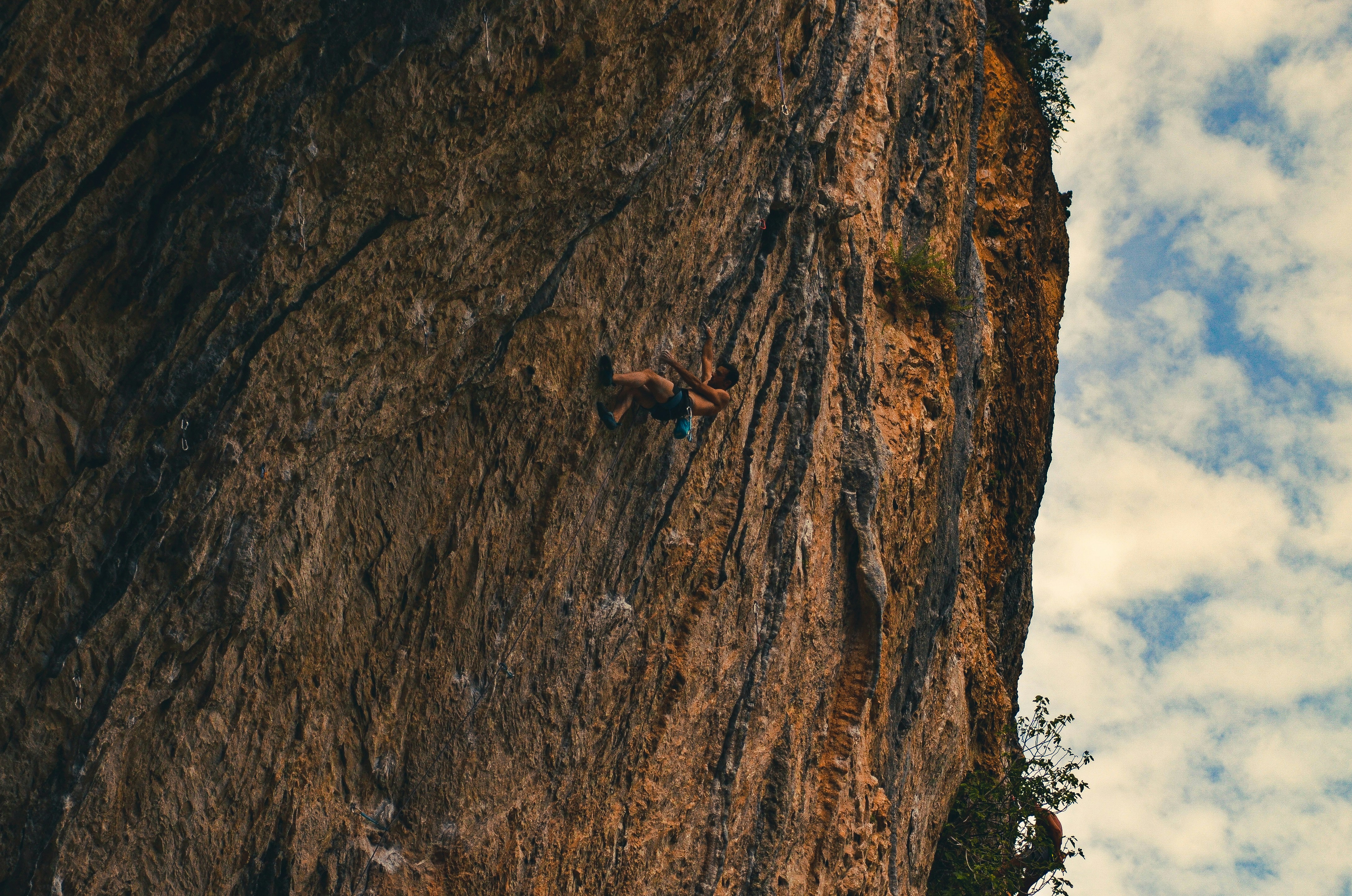 A rock climber ascends a steep cliff face. photo – Free Human Image on ...