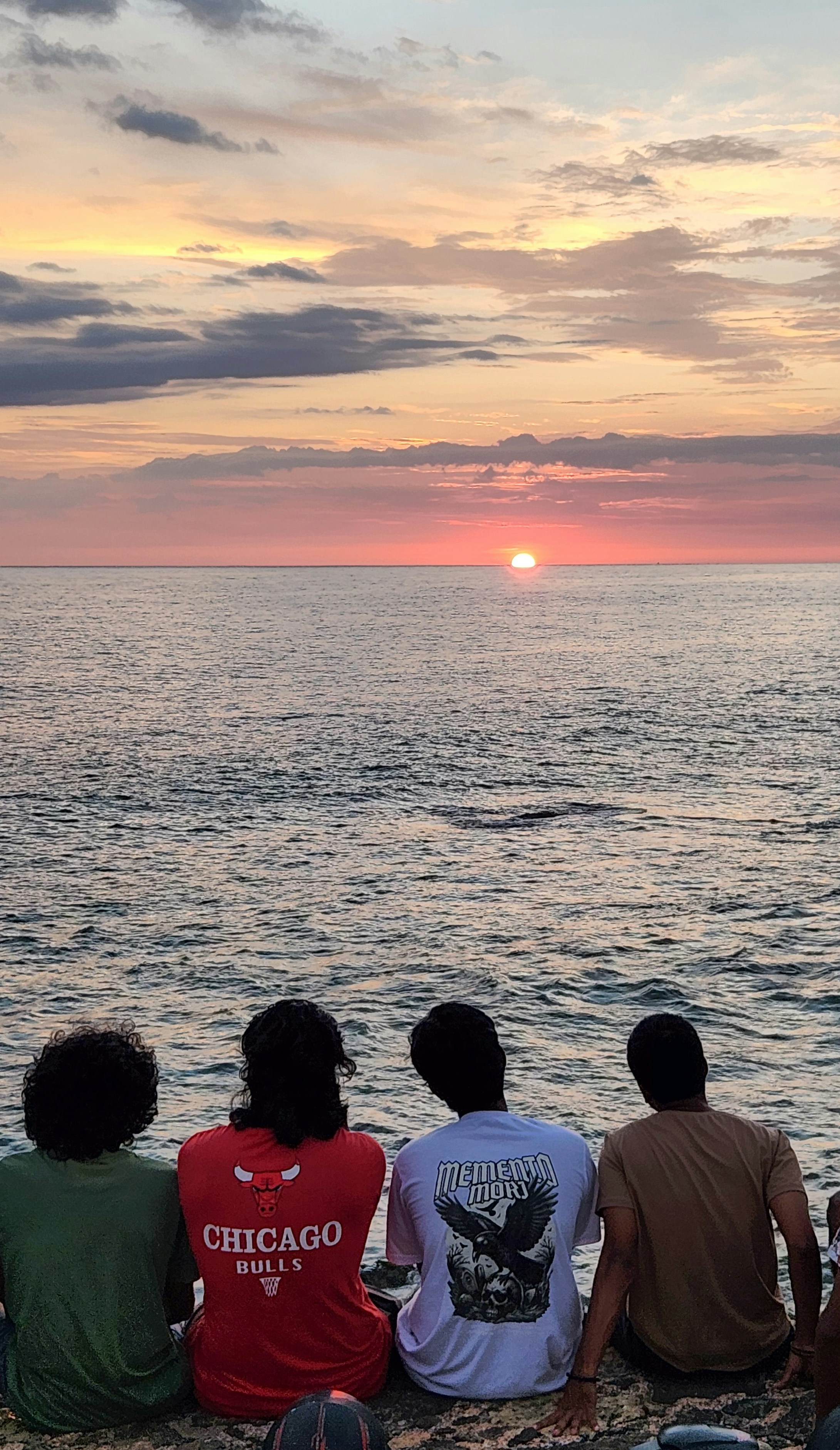 Sunset Watchers: Four Friends on the Shore Embracing Twilight