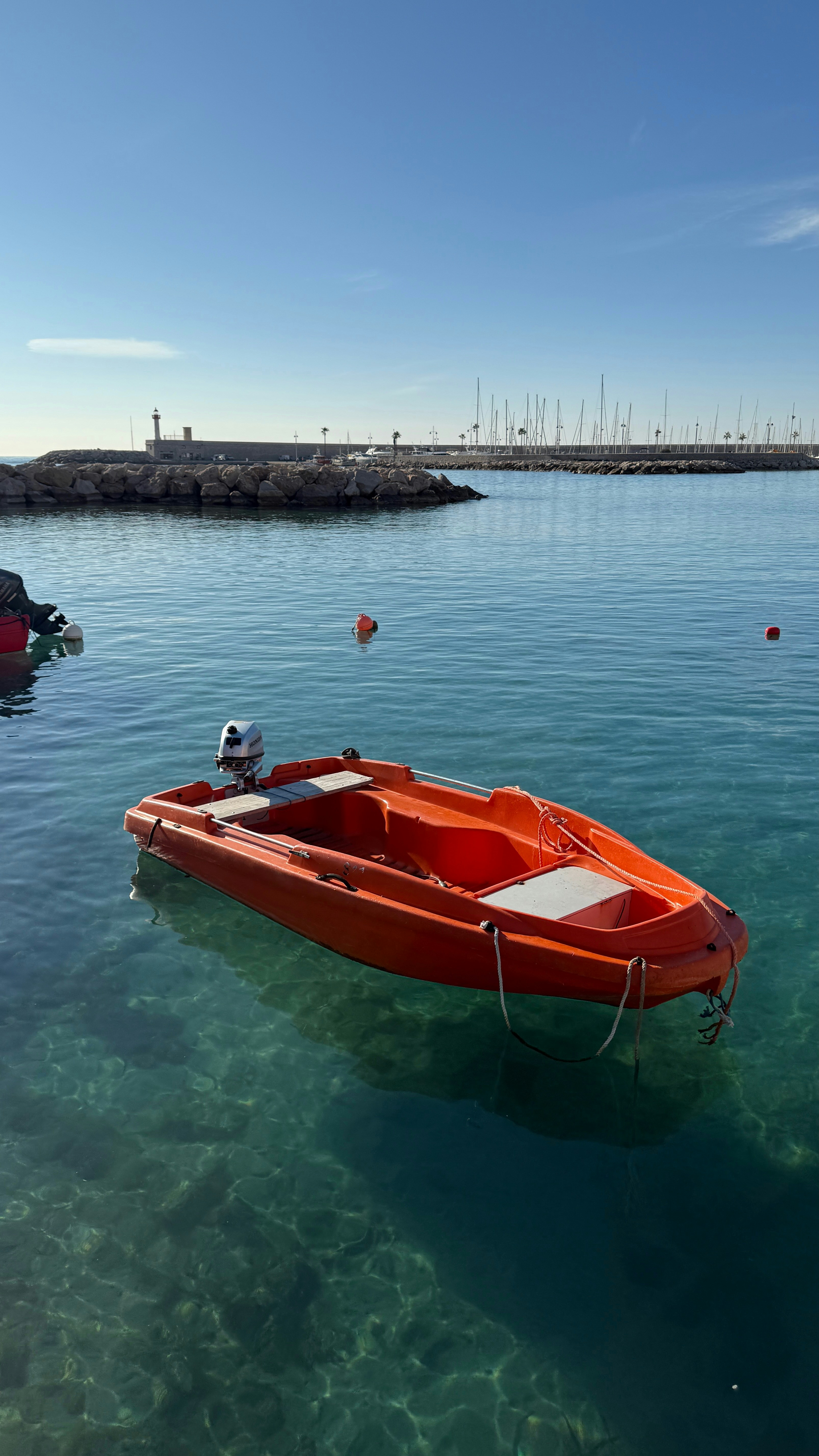 Orange Dinghy Anchors in Turquoise Harbor