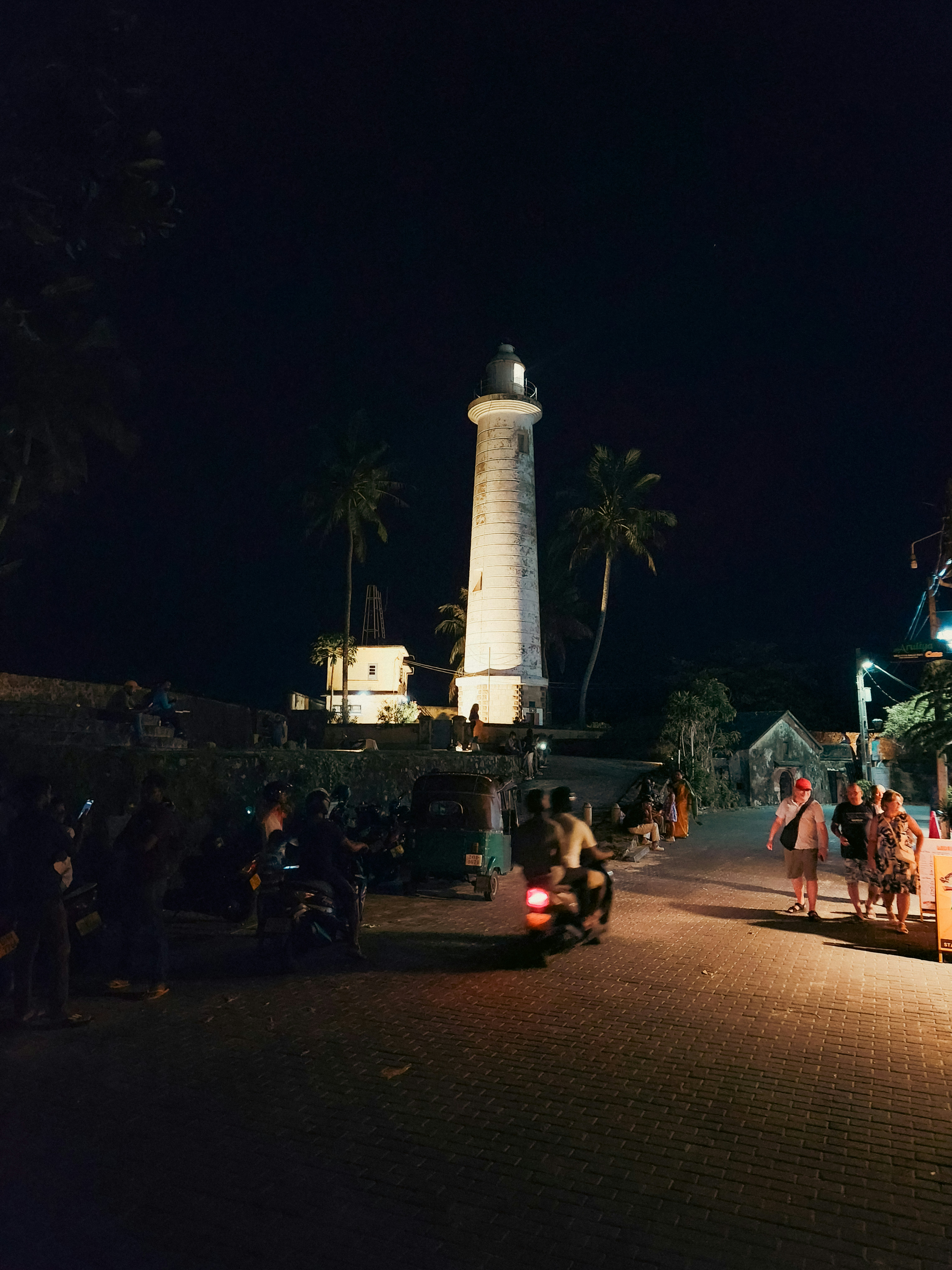 Lighthouse illuminated at night with a busy street. photo – Free Travel ...